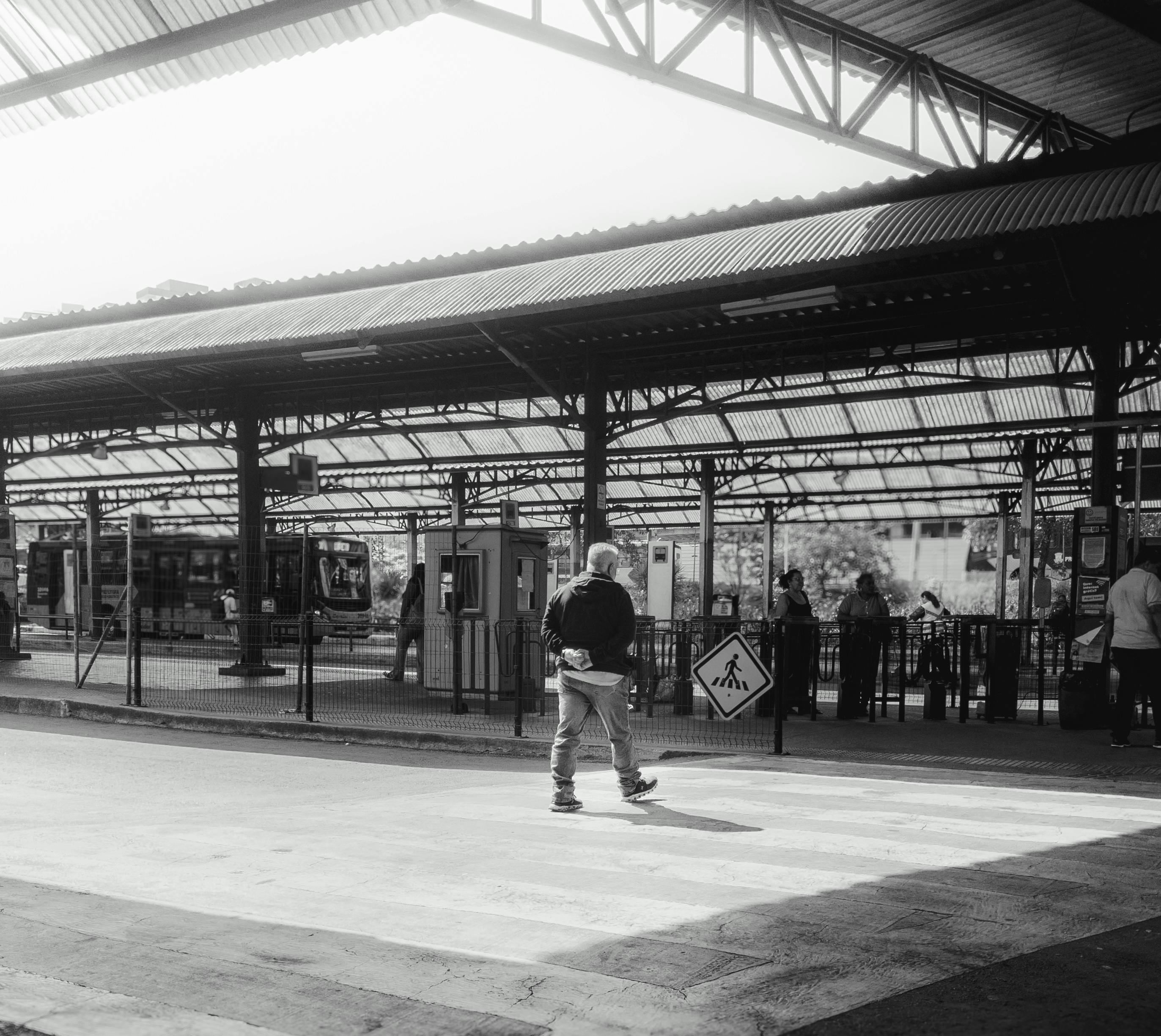 Black and White Bus Station Scene with Pedestrians · Free Stock Photo