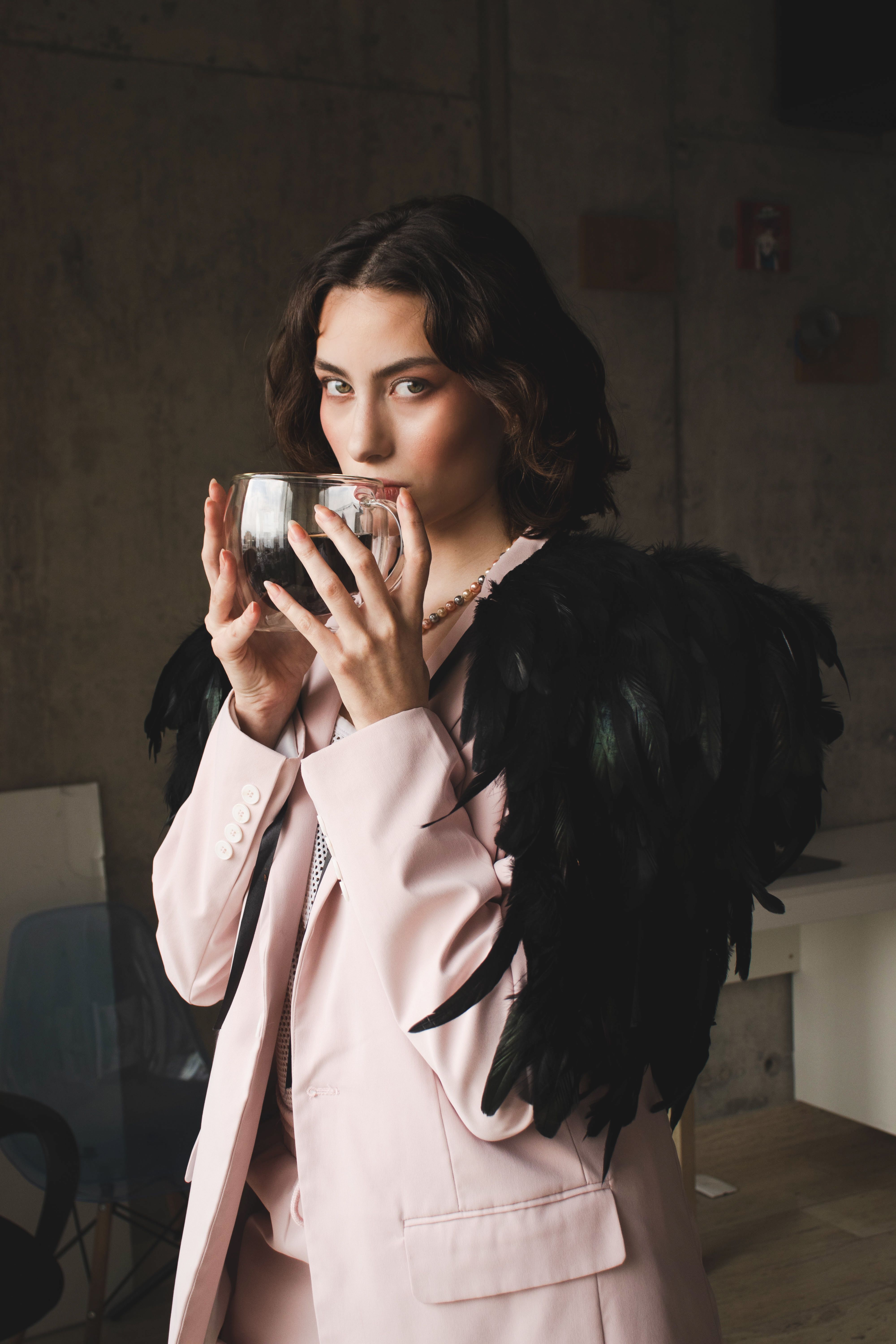 Young Adult with Angel Wings Drinking from Cup · Free Stock Photo