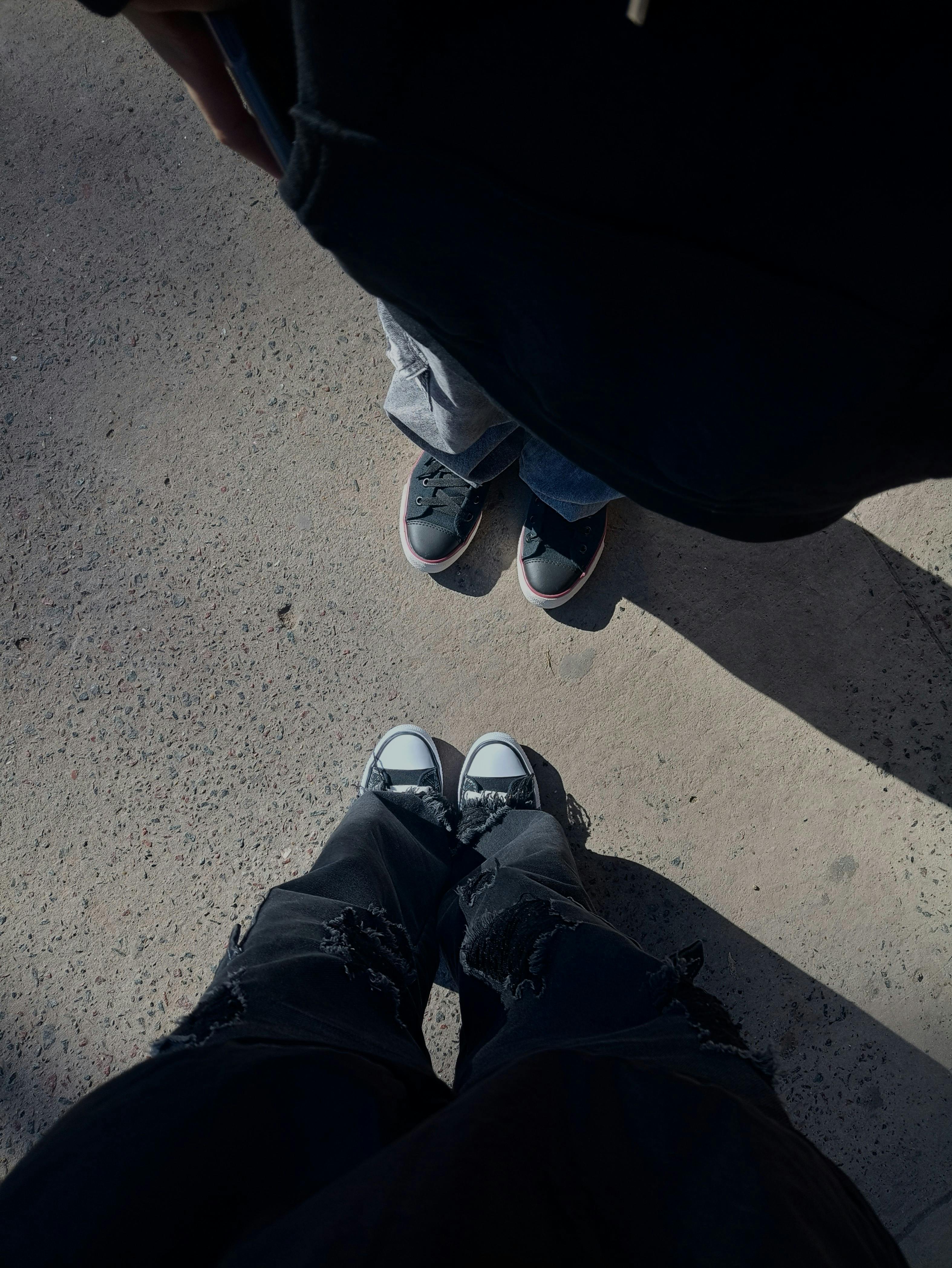 Casual Sneakers on Pavement with Shadows · Free Stock Photo