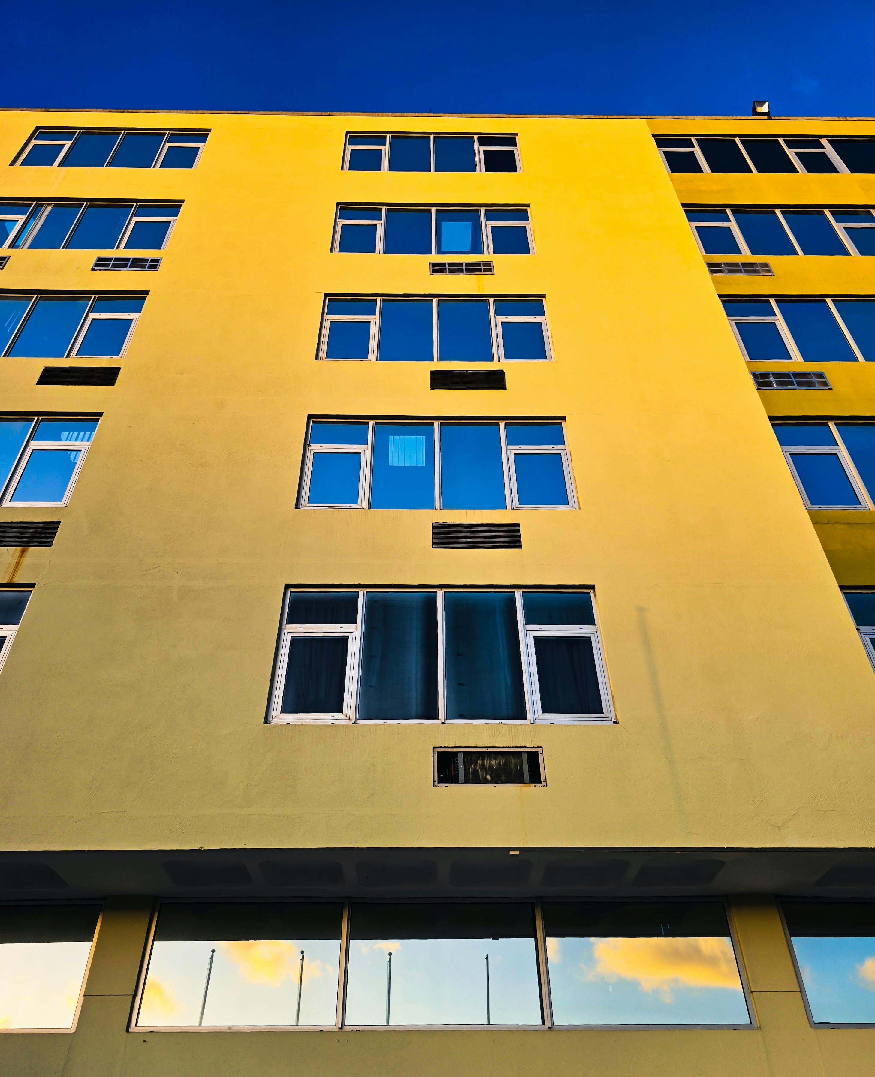 Bright Yellow Building with Blue Sky Contrast · Free Stock Photo