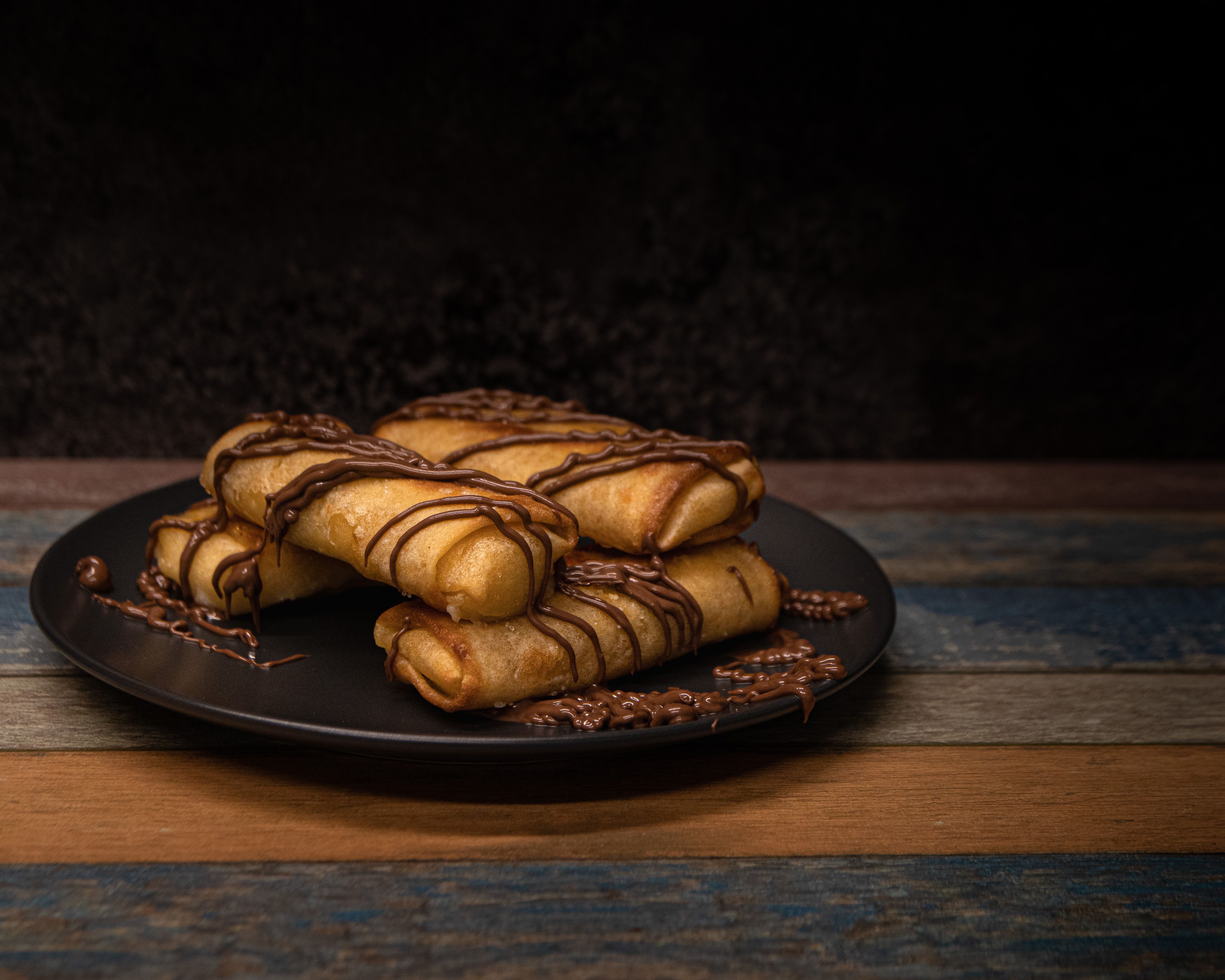 Delicious Chocolate Drizzled Pastry Rolls on Plate · Free Stock Photo