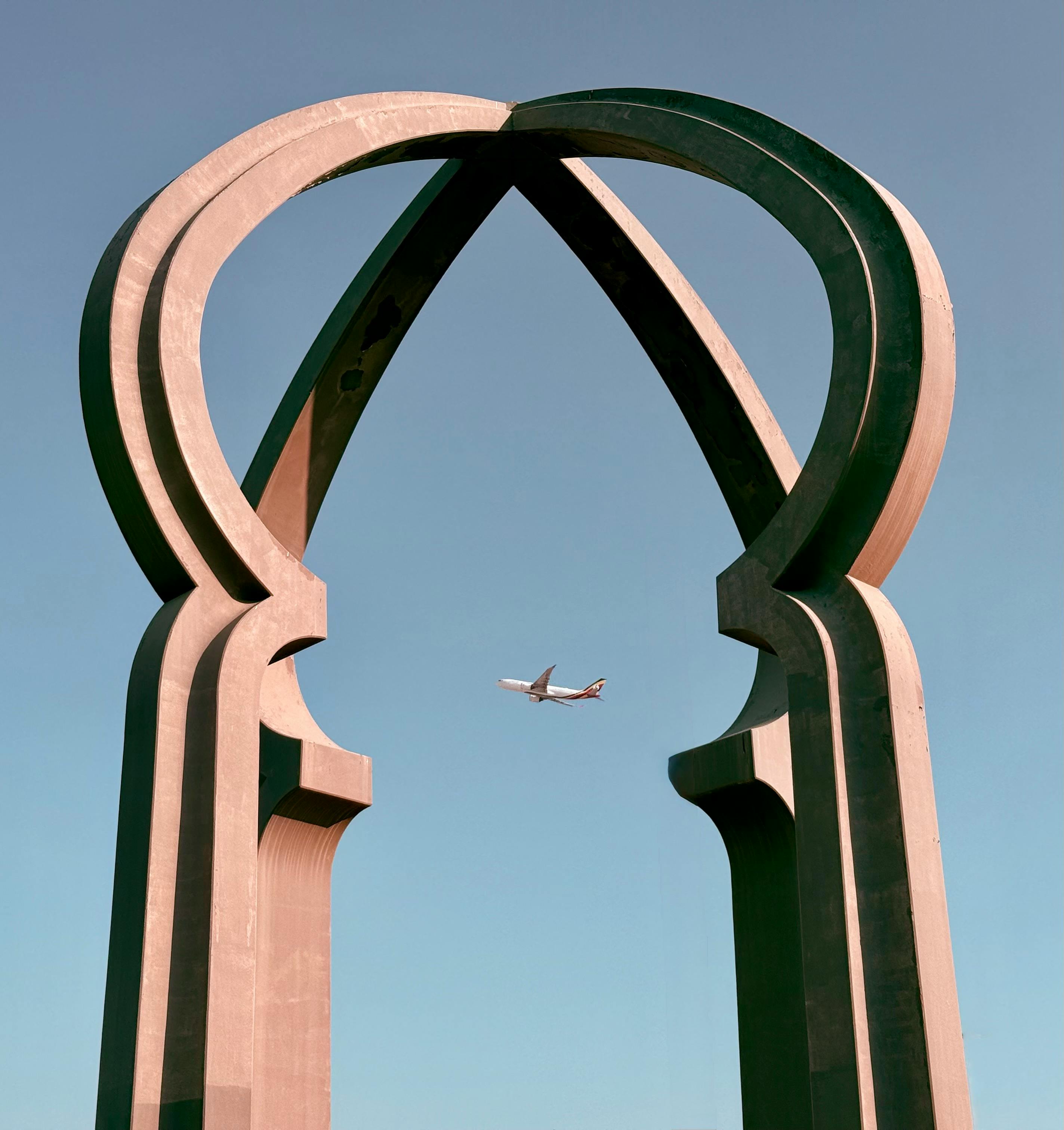 Airplane Framed by Modern Architectural Archway · Free Stock Photo