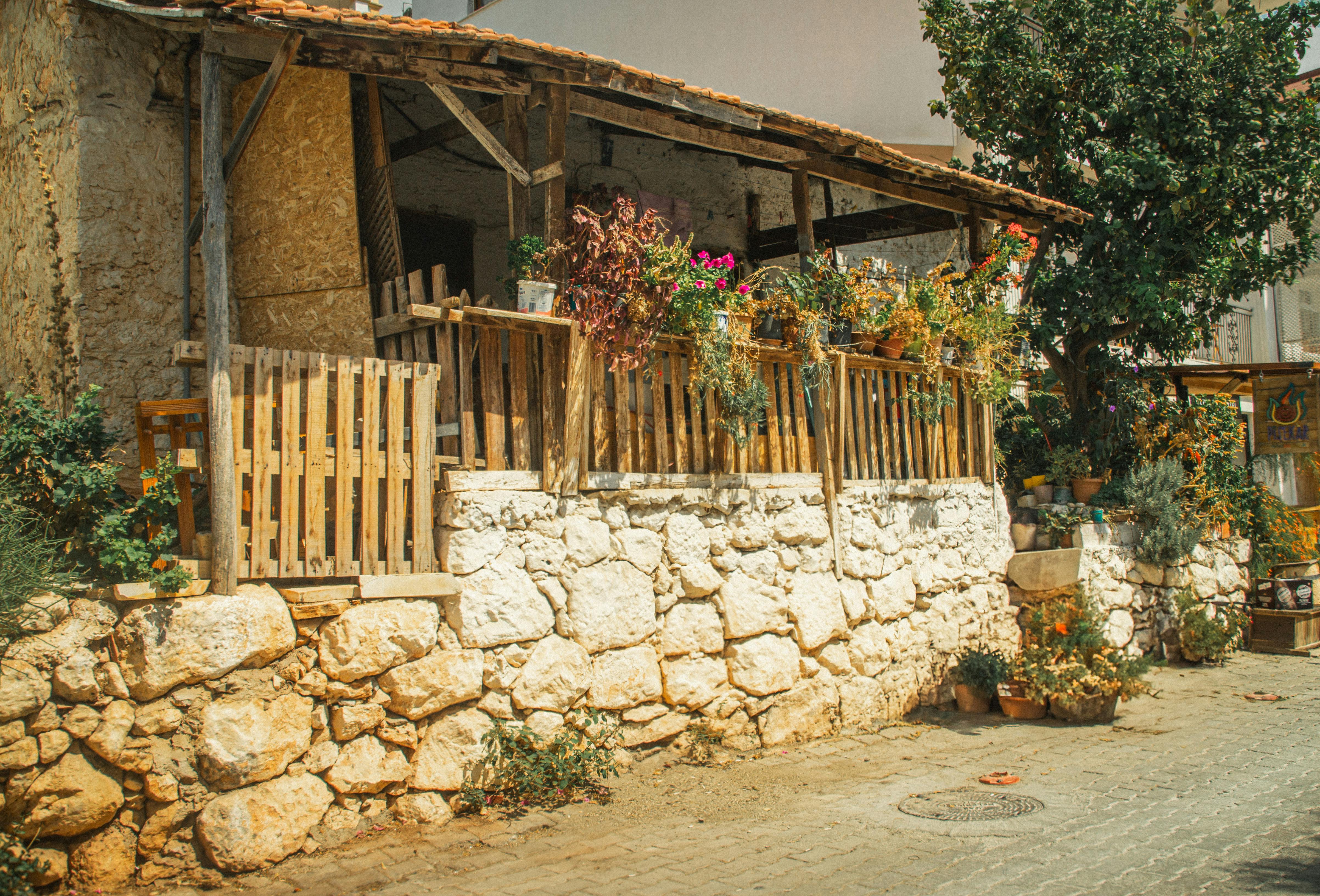 Charming Rustic Stone Cottage with Vibrant Flowers · Free Stock Photo