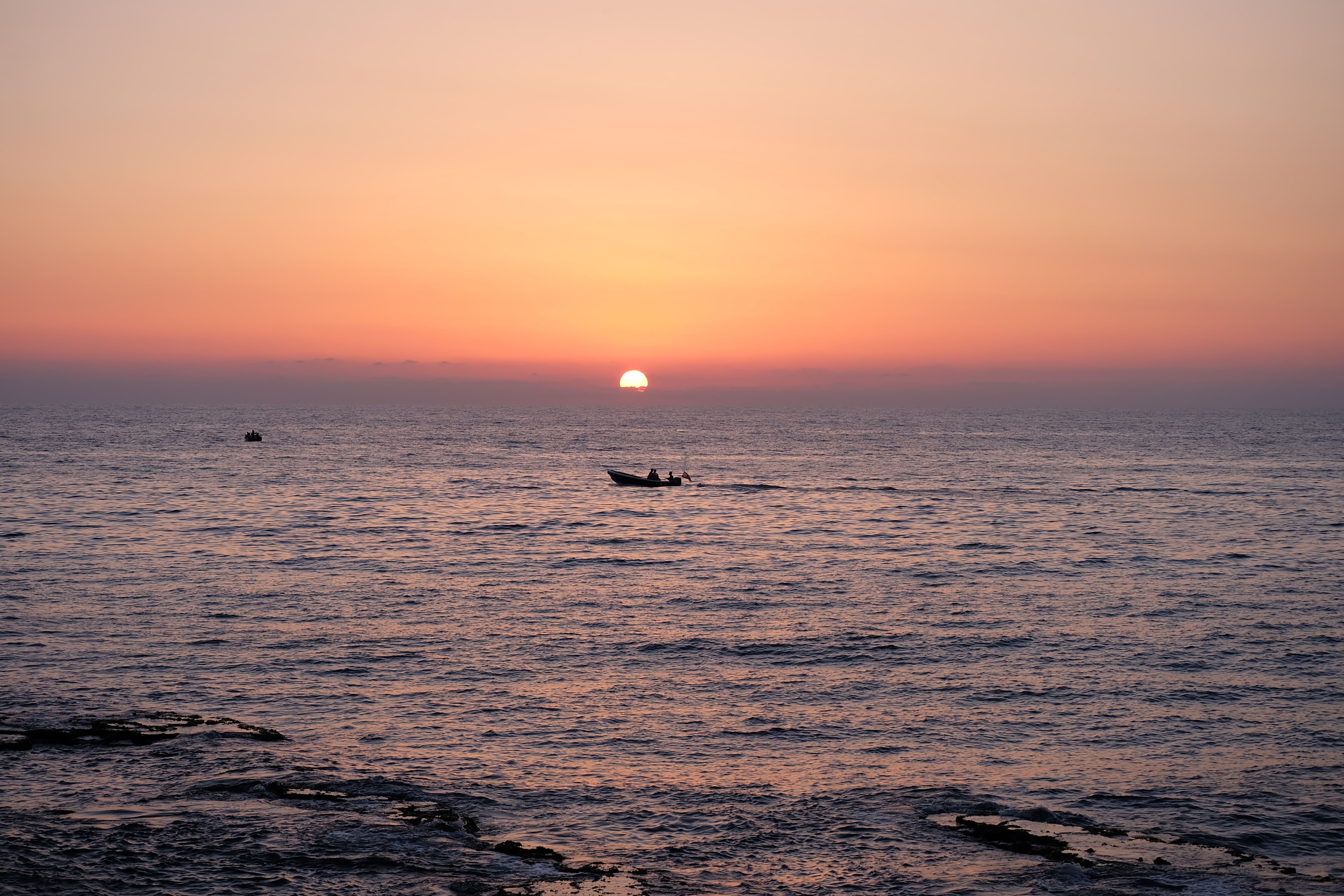 Serene Sunset Over the Ocean with Boat Silhouette · Free Stock Photo