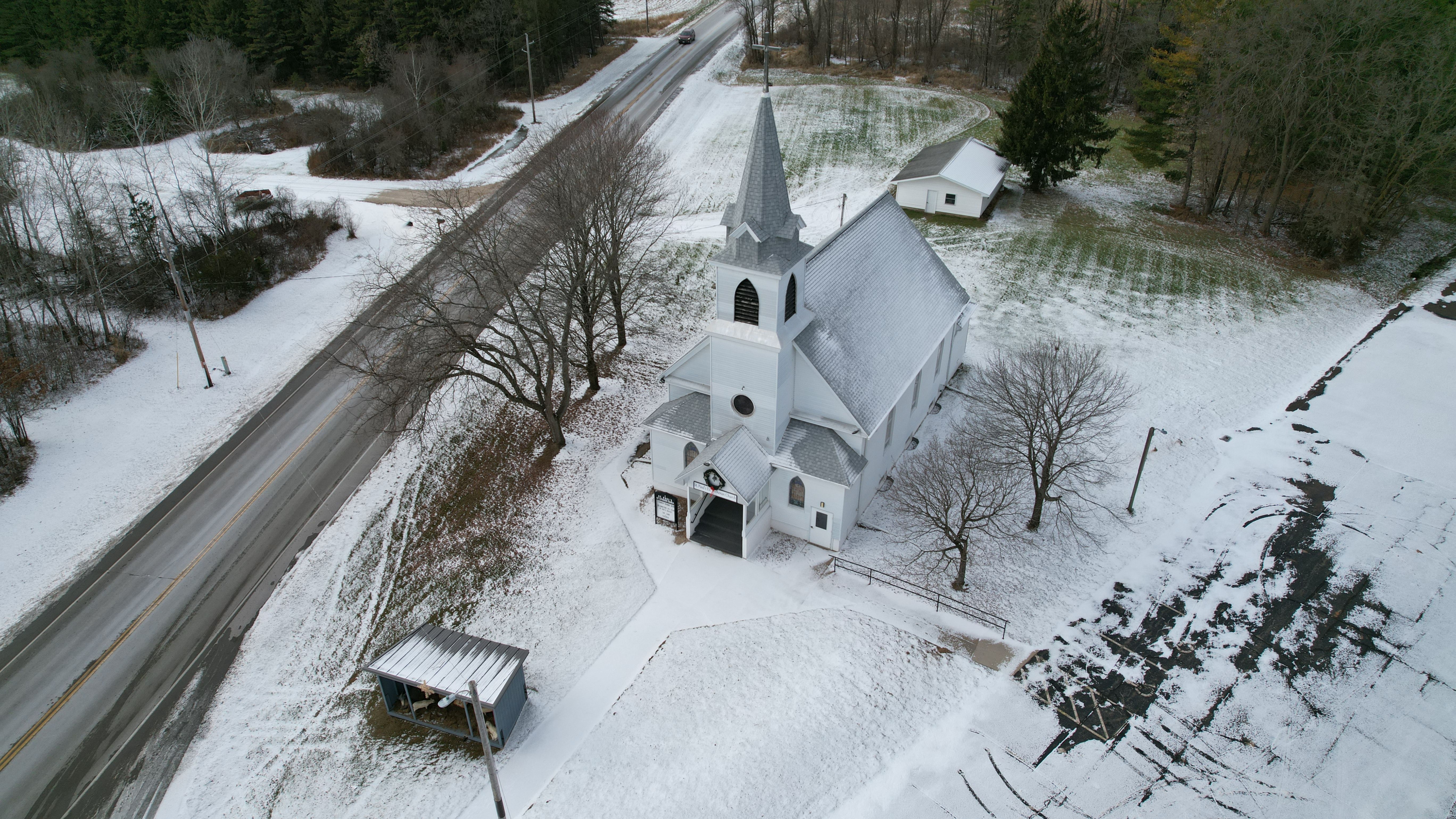 Aerial View of Snow-Covered Rural Church in Winter · Free Stock Photo