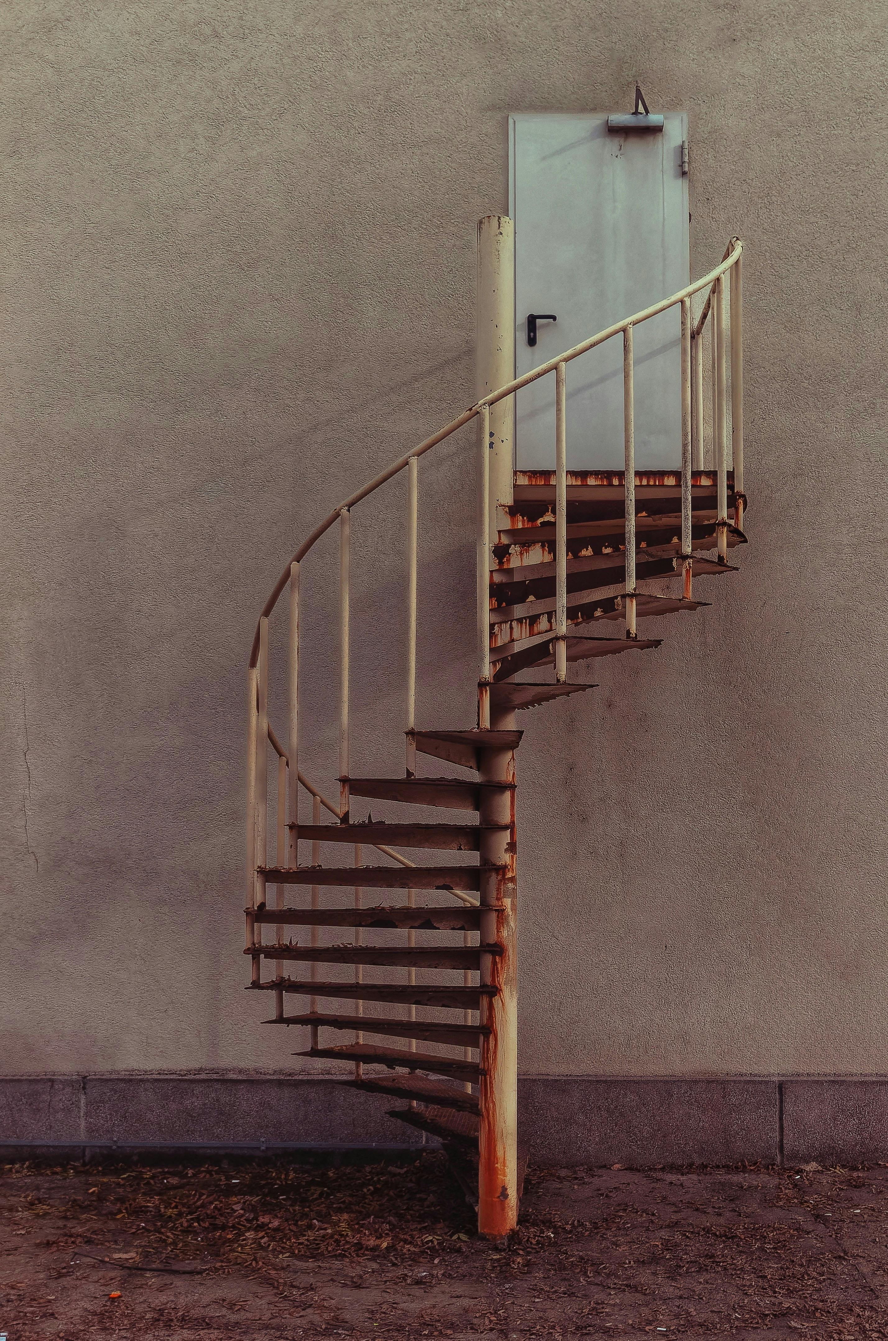 Rusty Spiral Staircase Leading to Doorway · Free Stock Photo