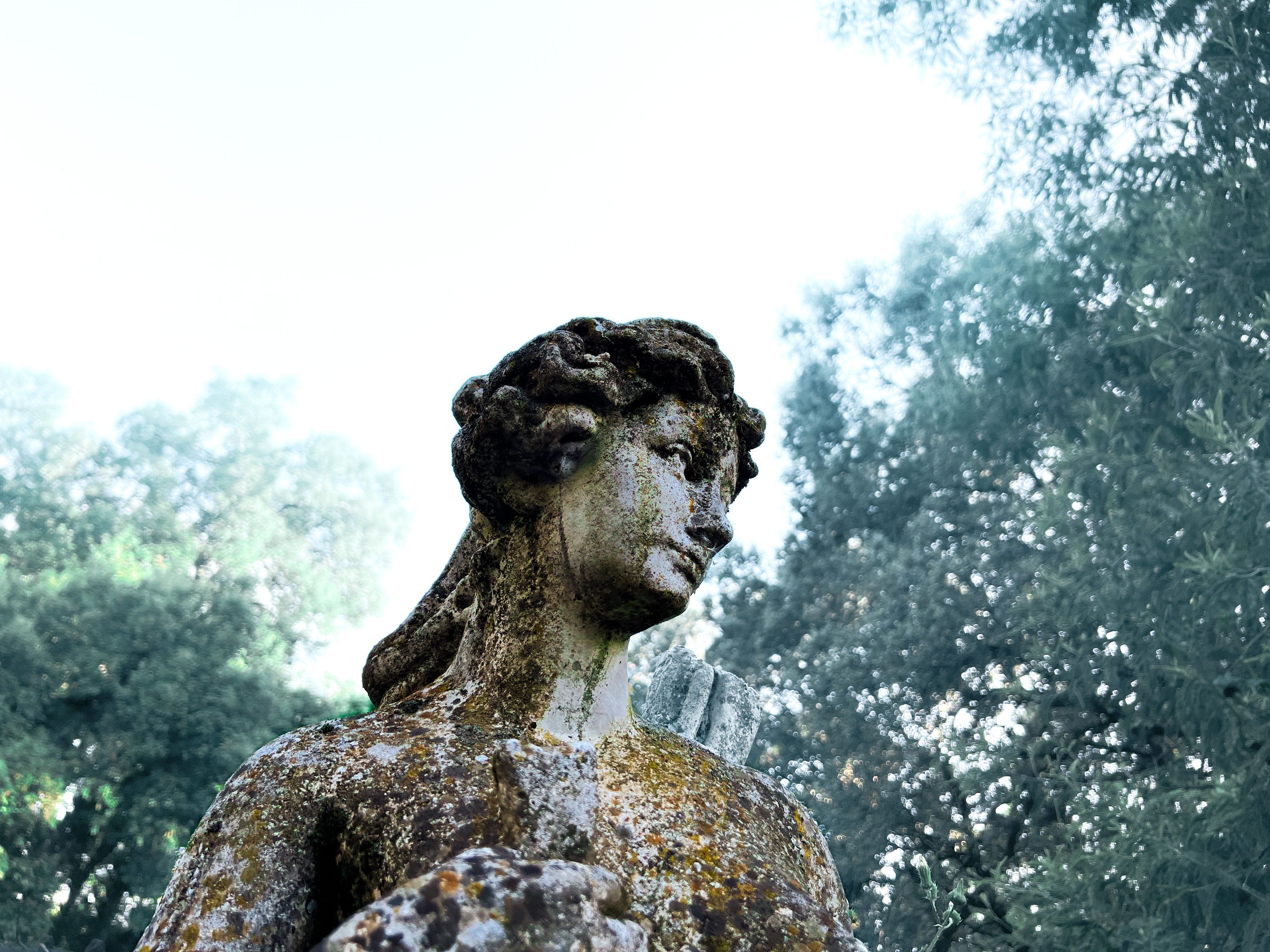 Ancient Stone Statue in Lush Garden Setting · Free Stock Photo
