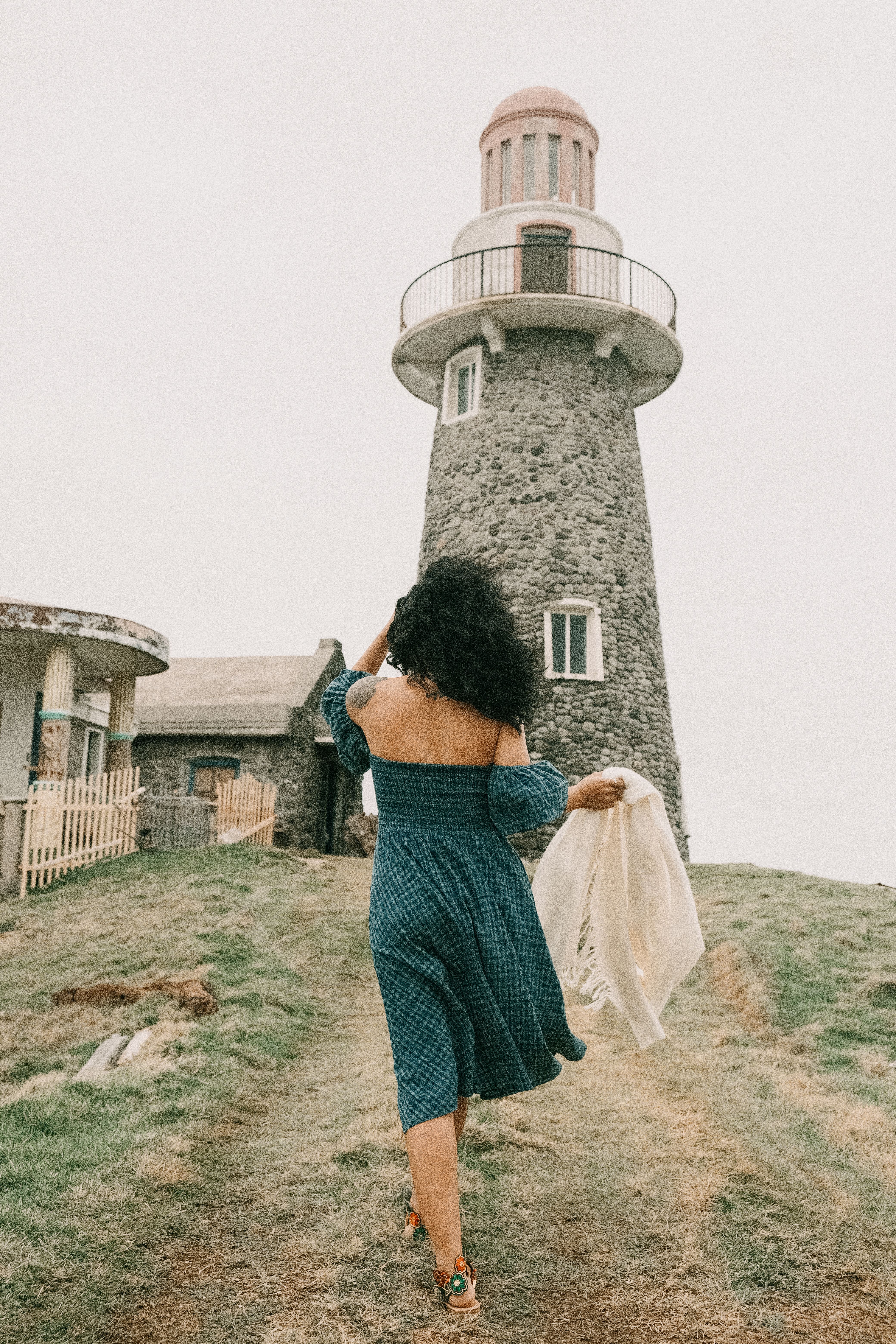 Woman Walking Towards Stone Lighthouse in Philippines · Free Stock Photo