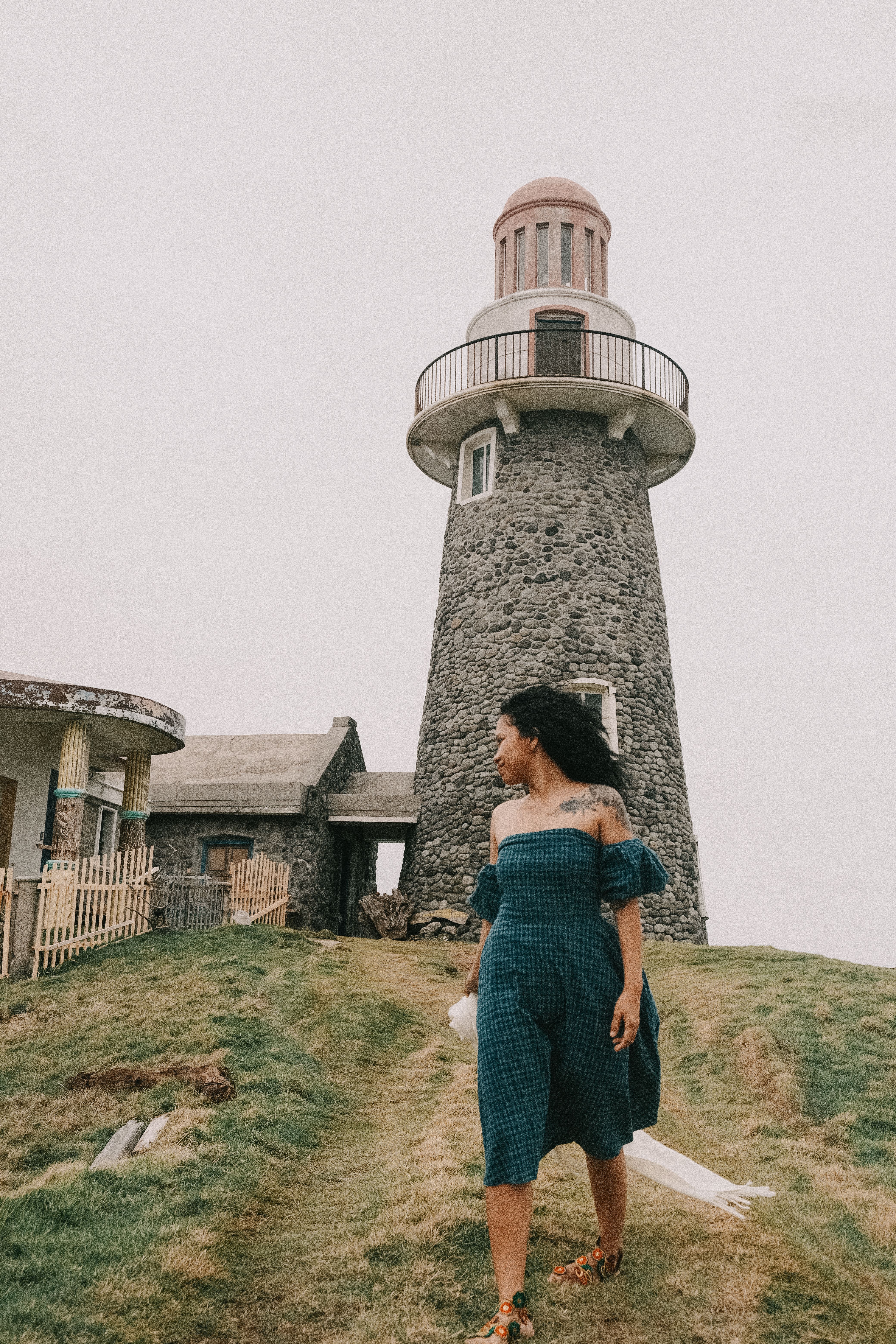 Woman Walking Near Stone Lighthouse in Cagayan Valley · Free Stock Photo