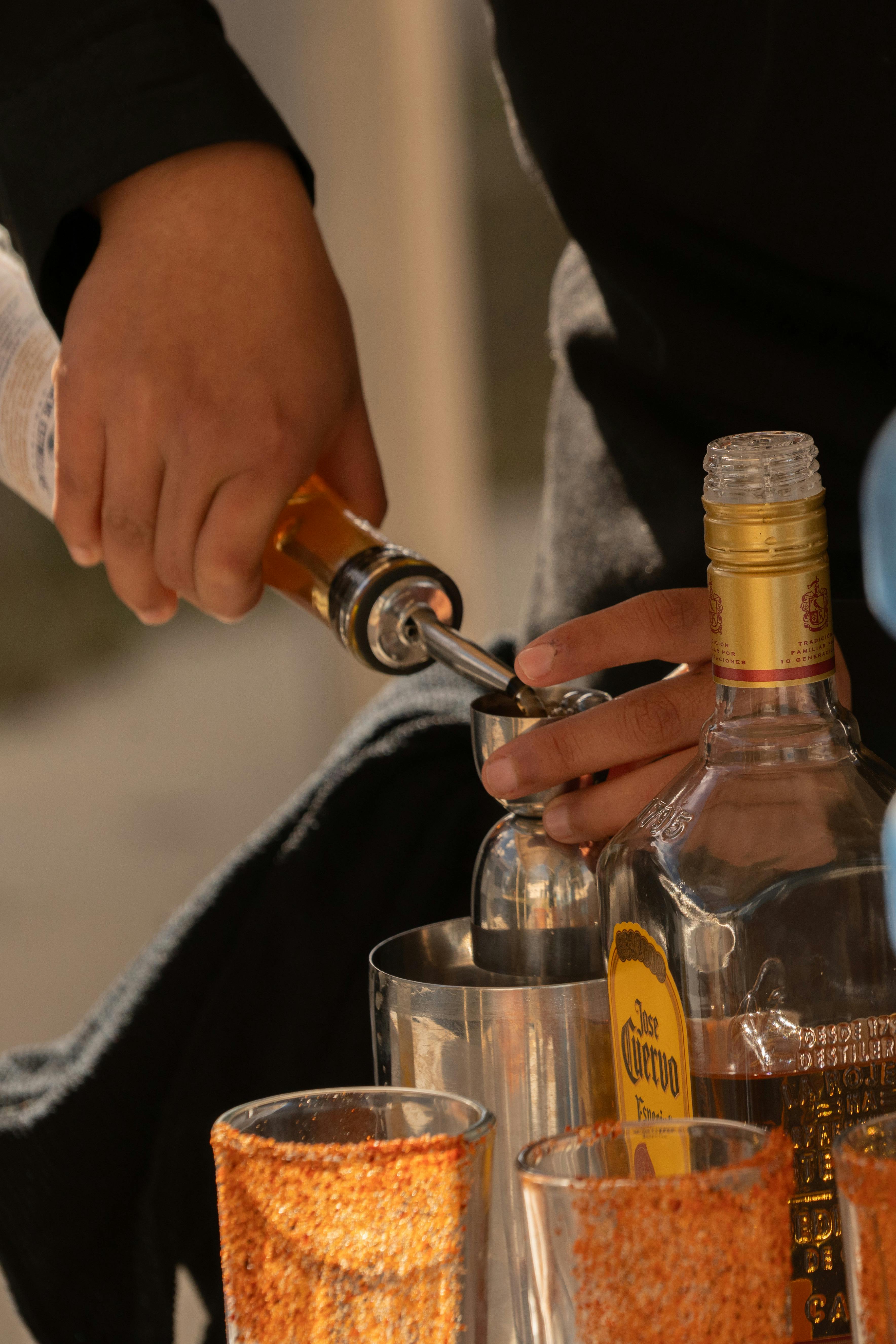 Close-up of hand pouring drink from cocktail shaker into glass · Free ...