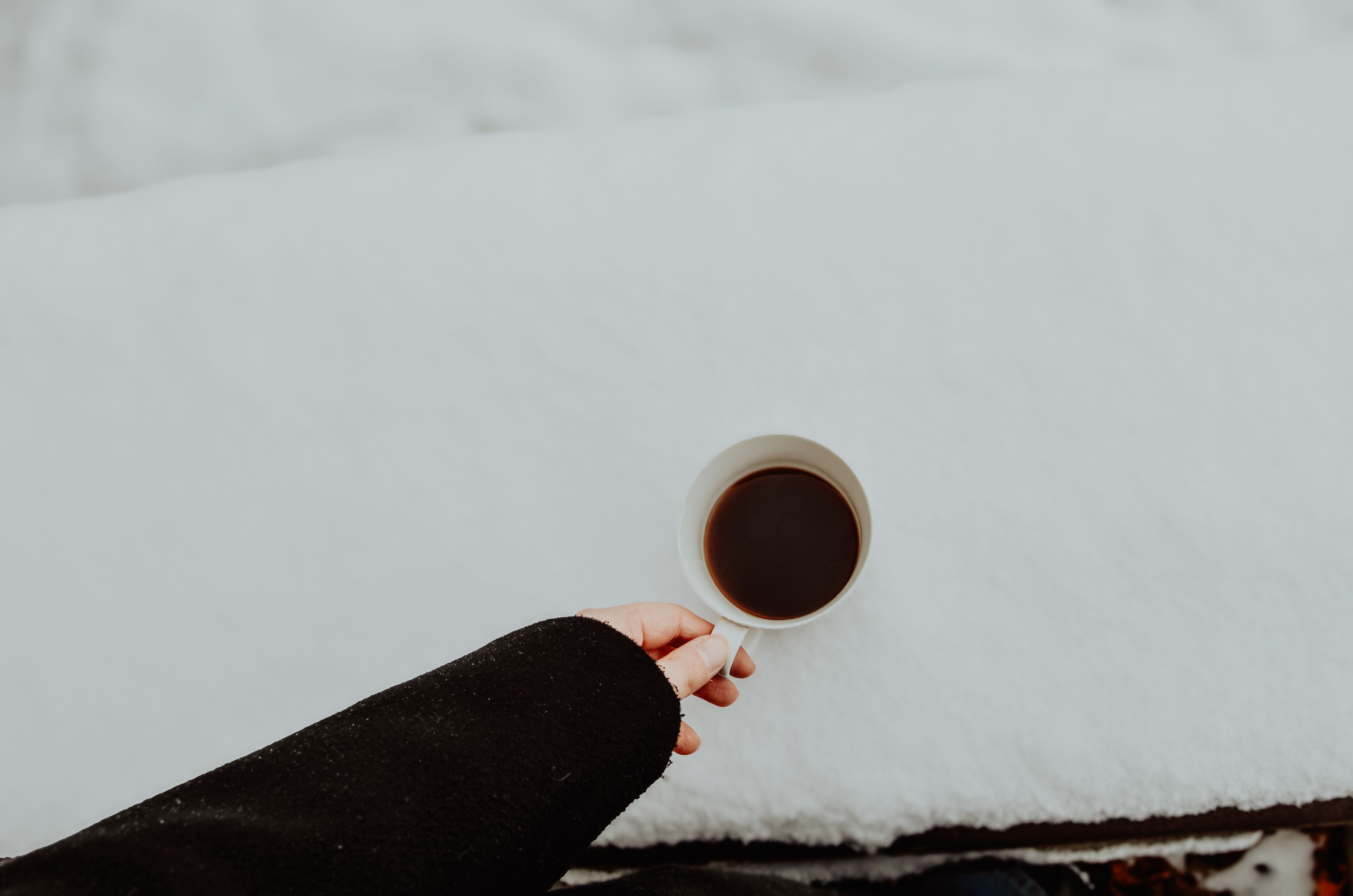 Cozy Winter Coffee Moment in Snowy Outdoor Setting · Free Stock Photo