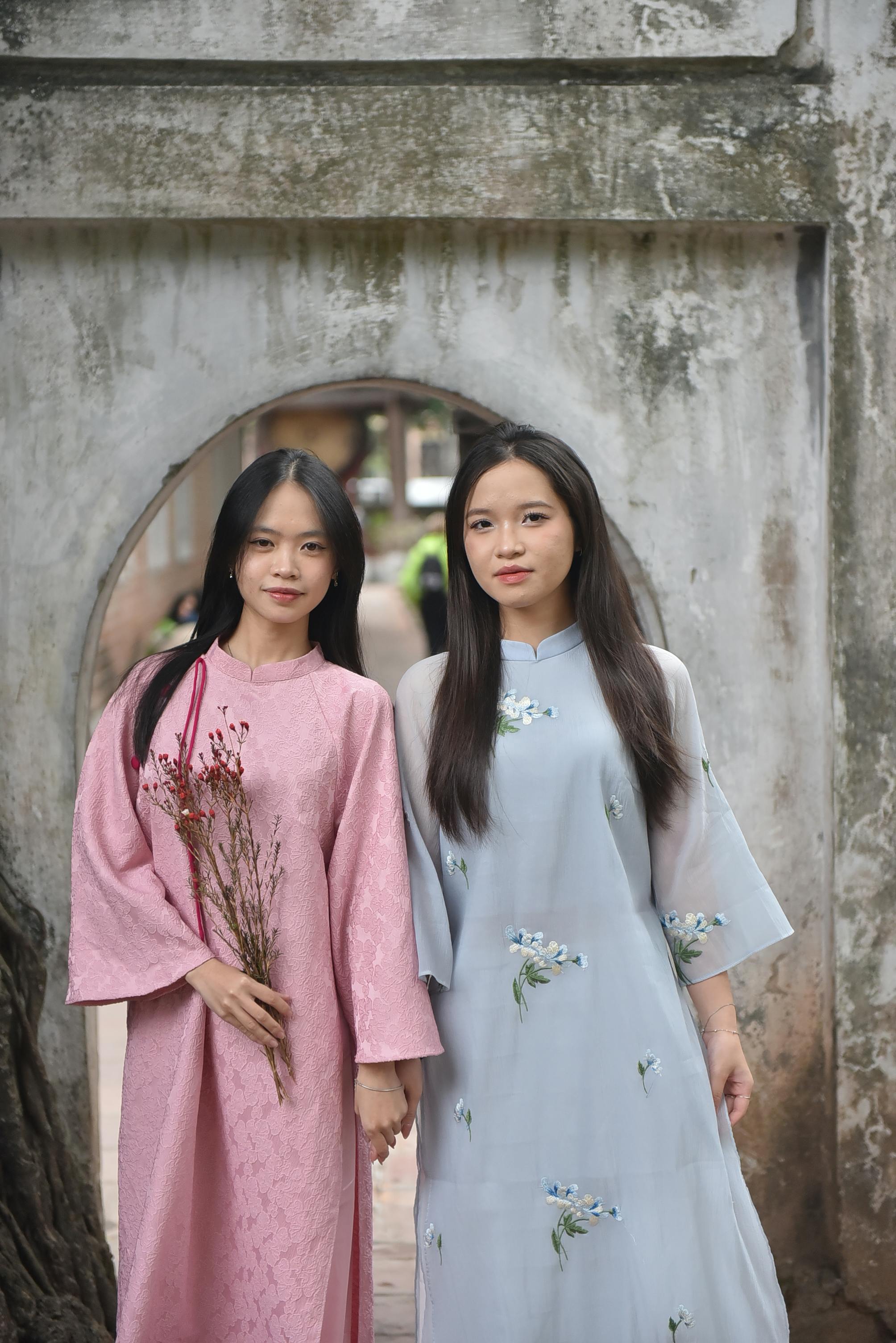 Young Women in Traditional Dresses at Ancient Gateway · Free Stock Photo