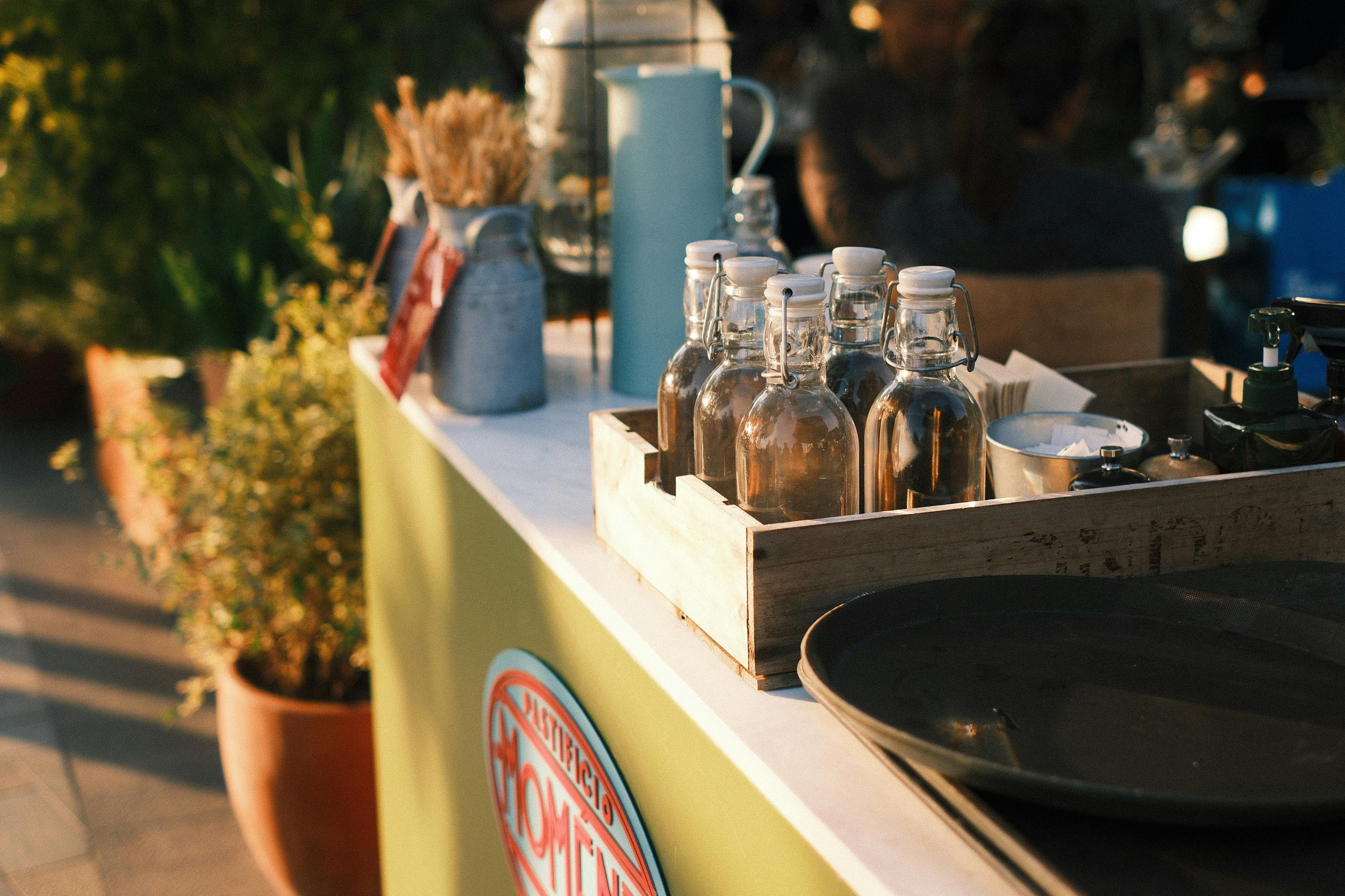 Outdoor Cafe Display with Rustic Bottles · Free Stock Photo
