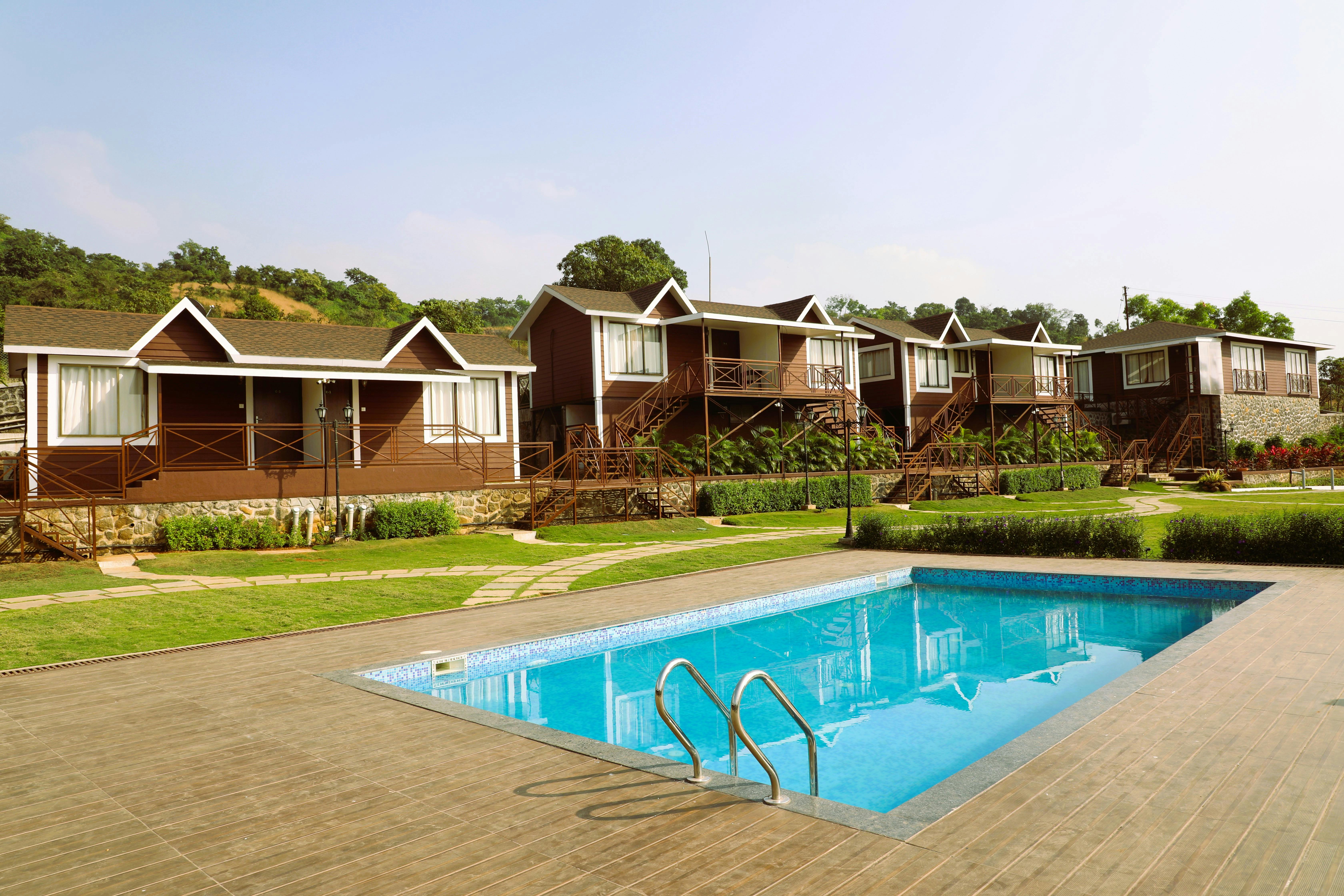 Charming Cabins with Outdoor Pool and Greenery · Free Stock Photo