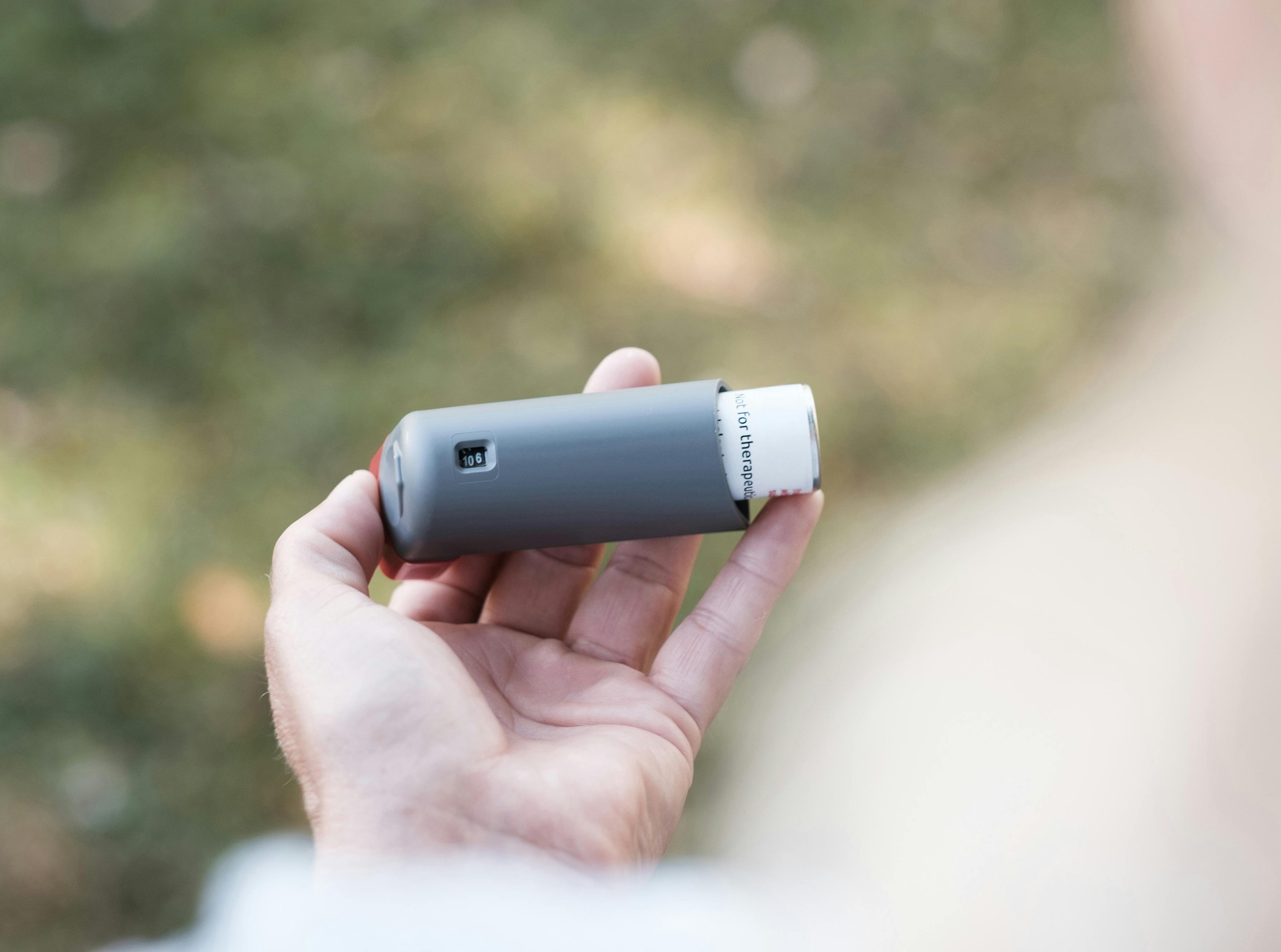 Hand Holding Grey Inhaler Outdoors · Free Stock Photo