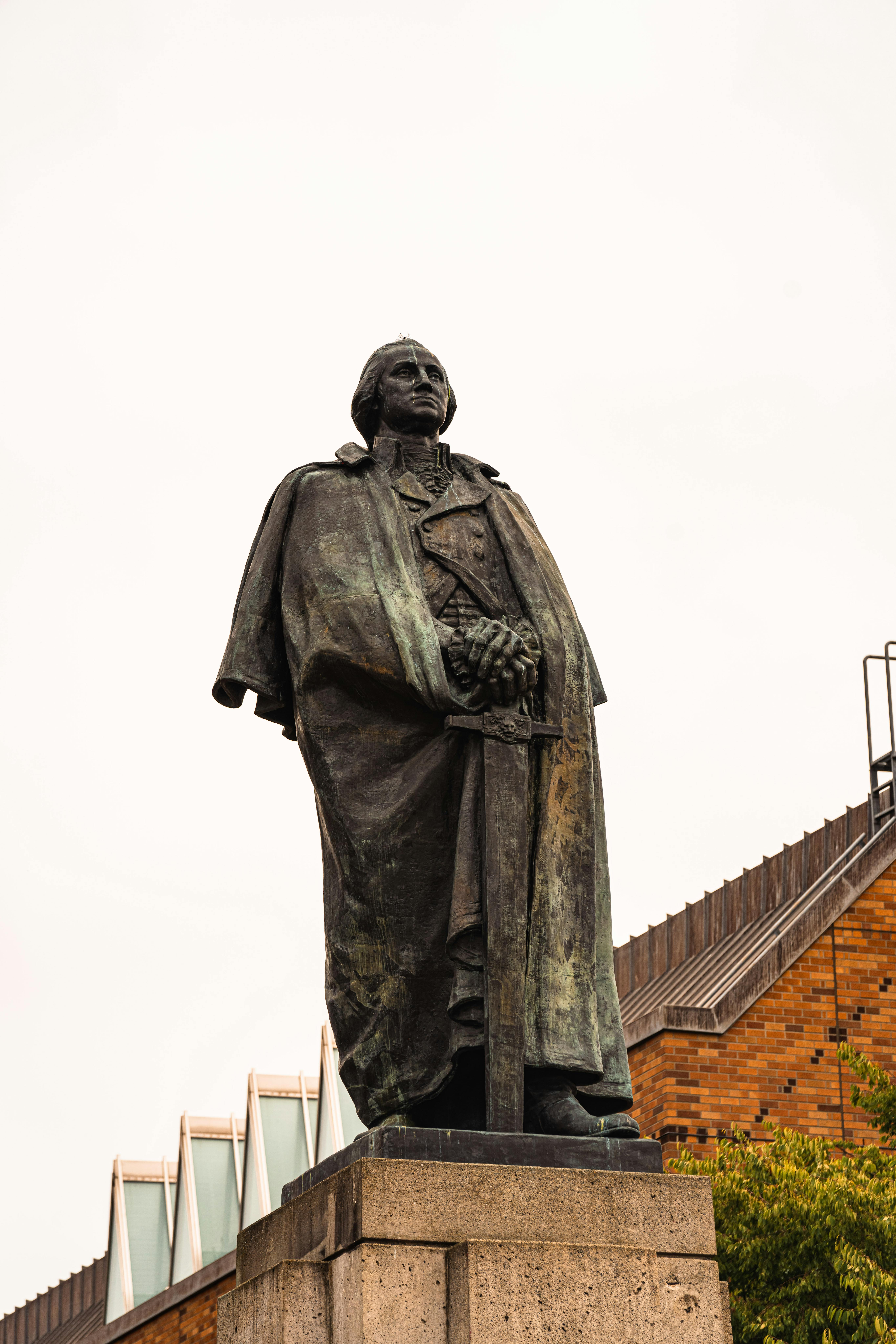 Dramatic Statue Against Historic Building · Free Stock Photo