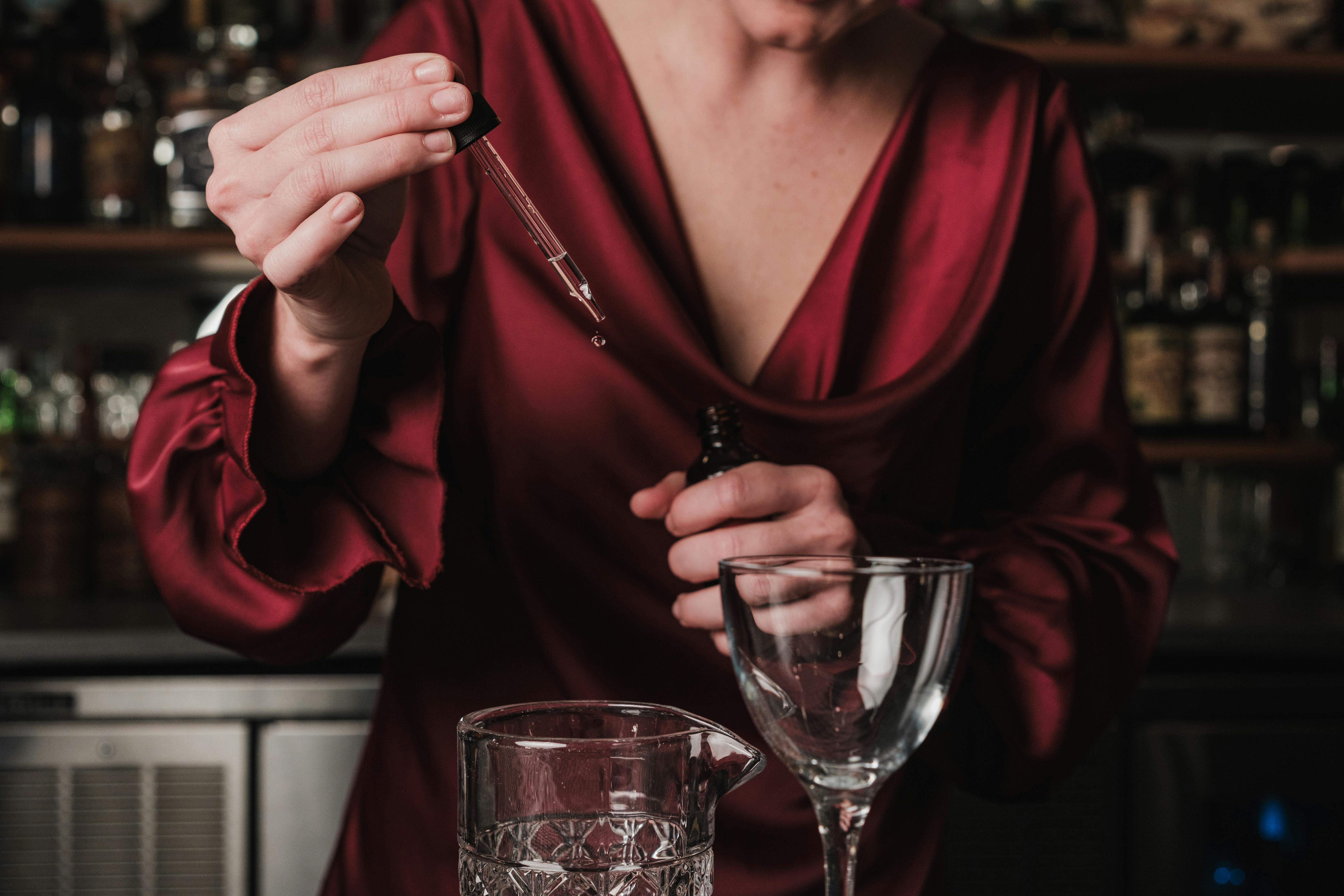 Mixologist Adding Bitters in Cocktail Preparation · Free Stock Photo