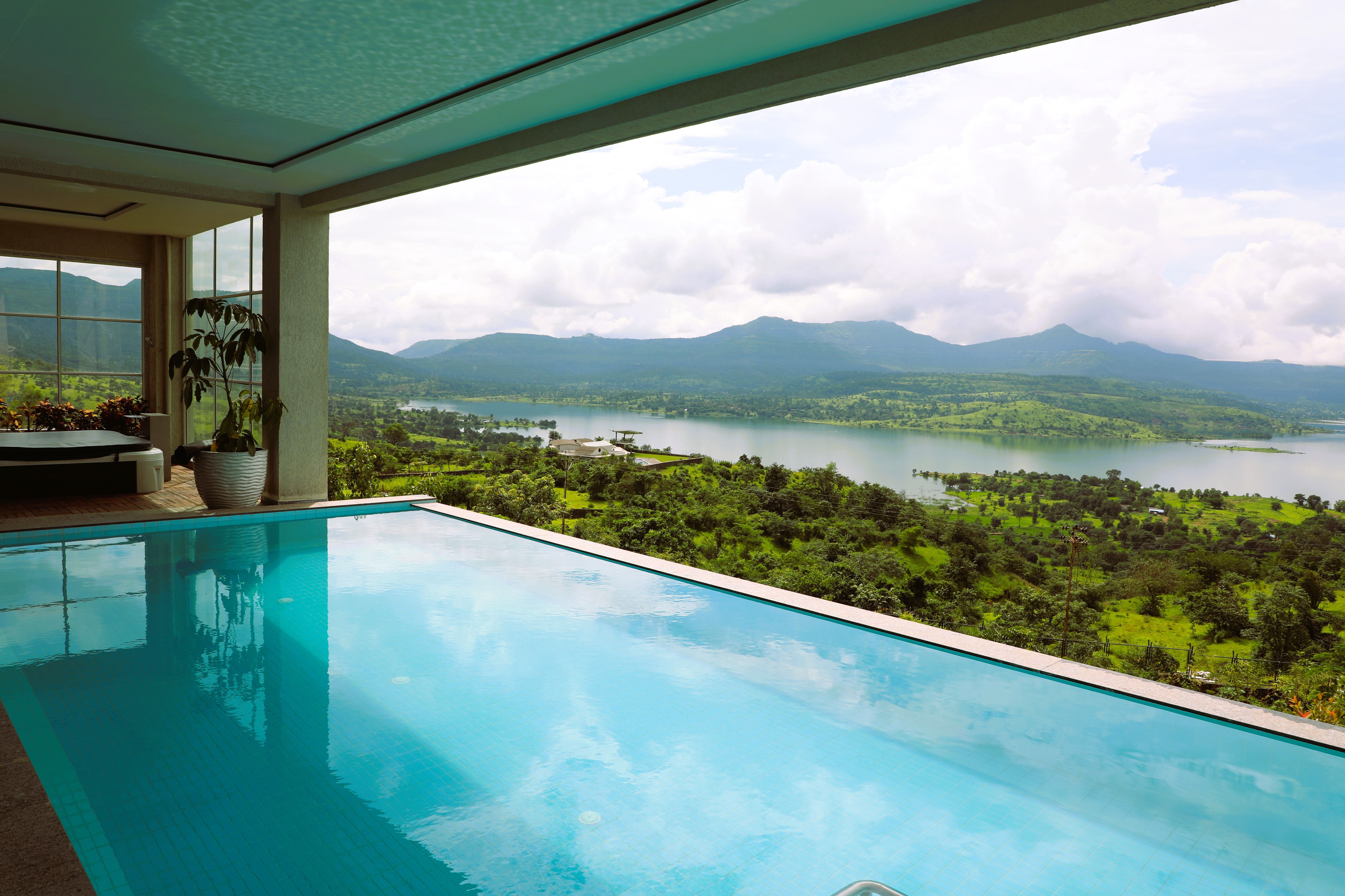Luxurious Lakeside Infinity Pool with Scenic View · Free Stock Photo