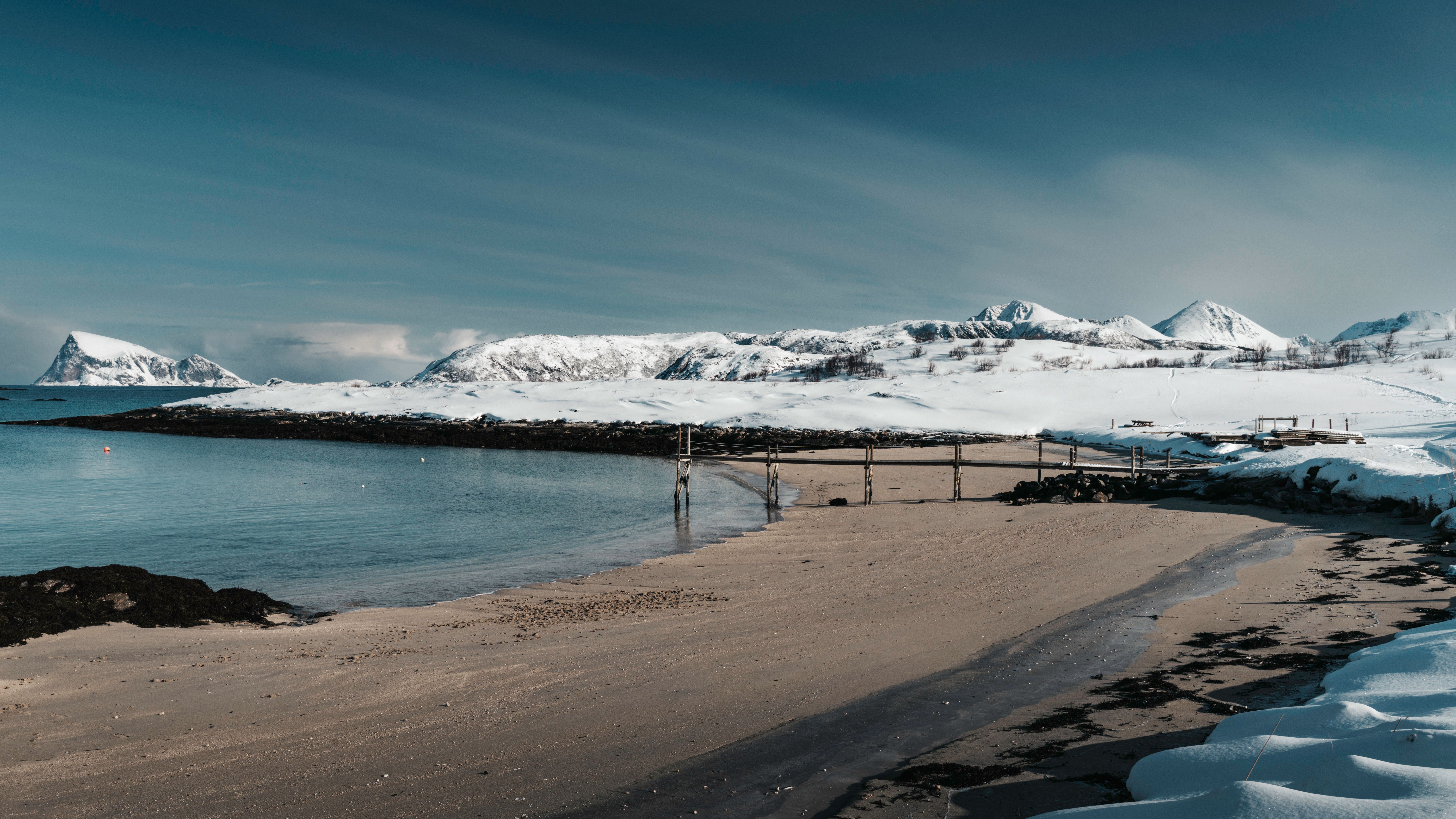 Scenic Snowy Beach with Mountain View · Free Stock Photo