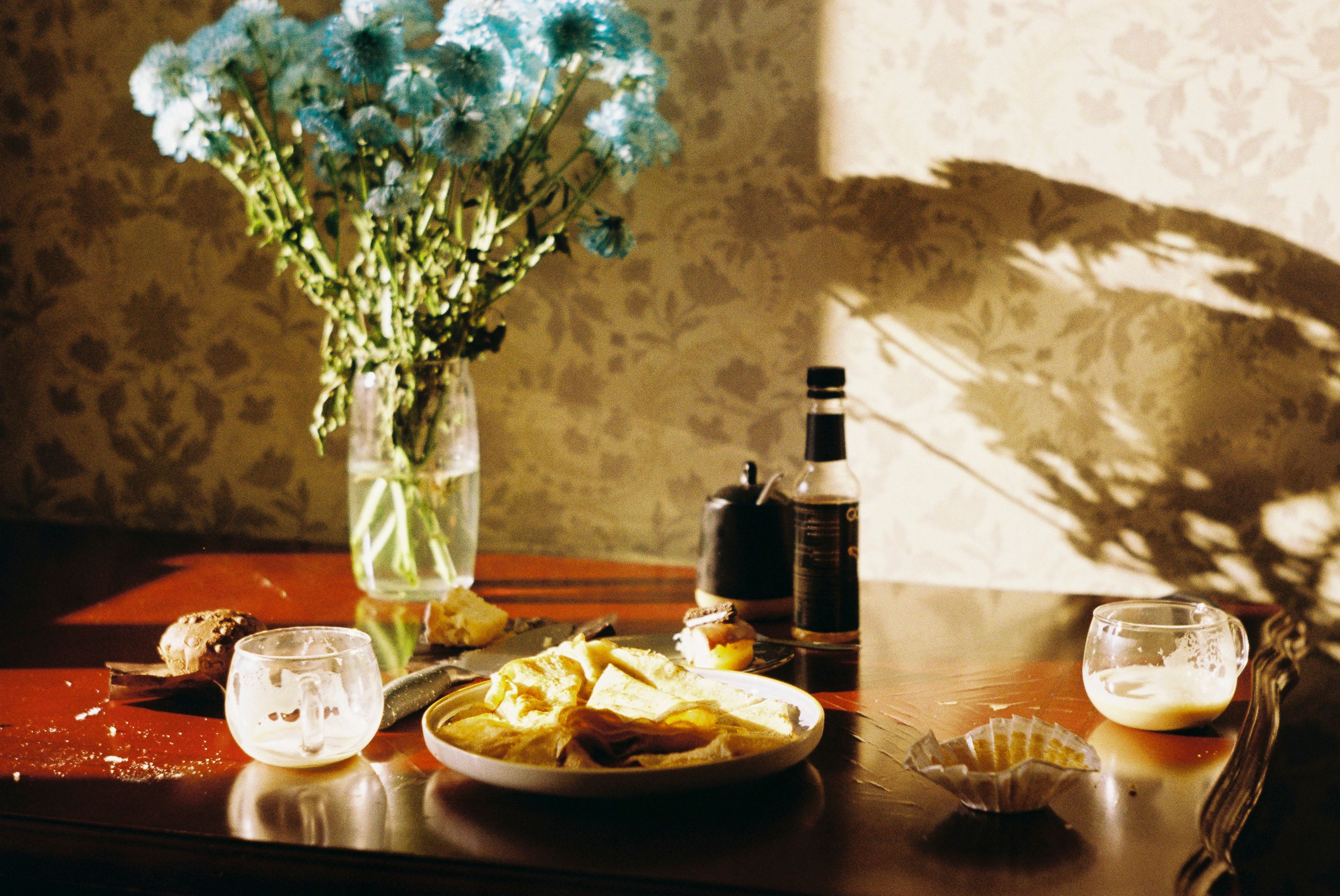 Cozy Breakfast Scene with Flowers in Soft Morning Light · Free Stock Photo