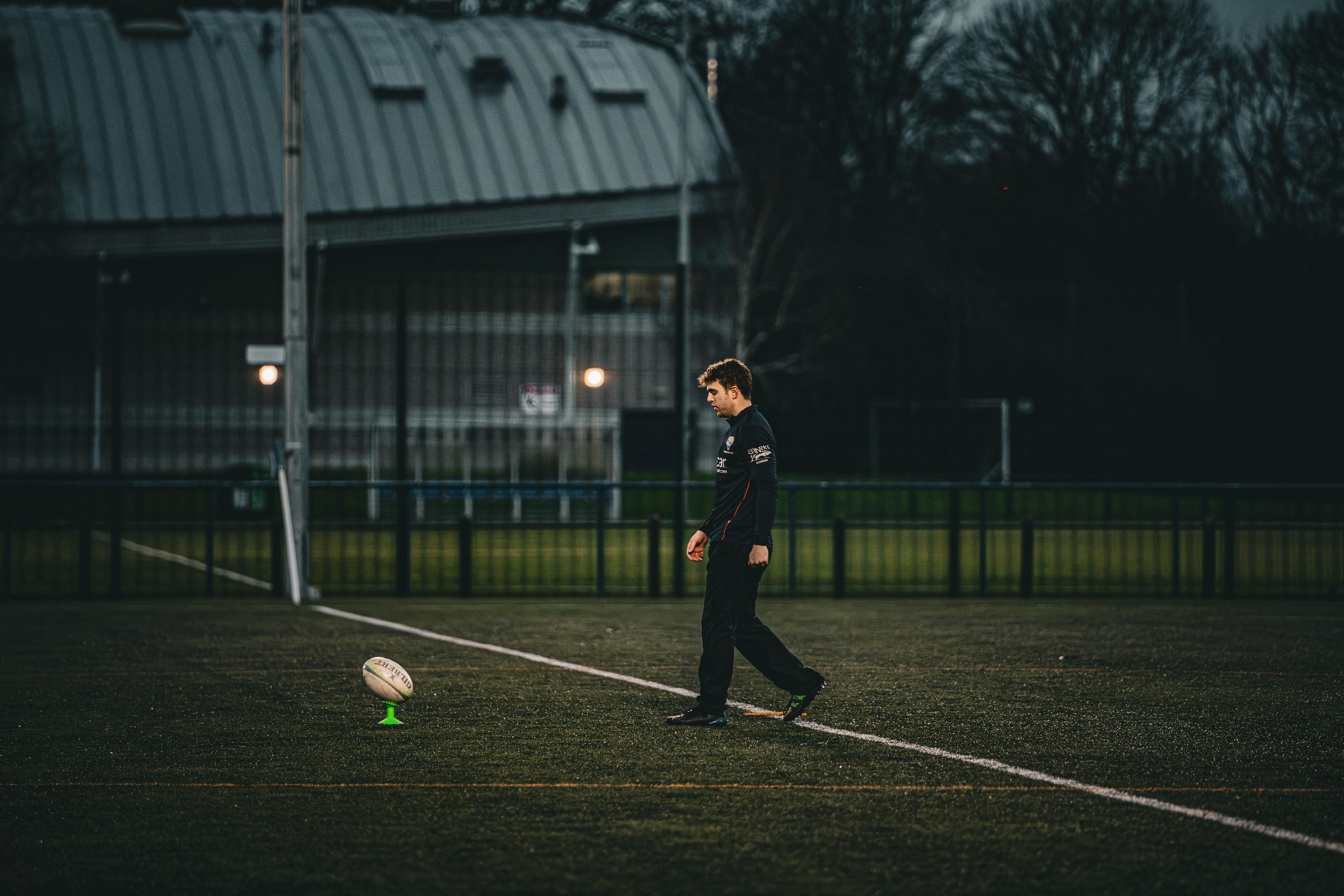 Rugby Player Preparing for Kick on Field · Free Stock Photo