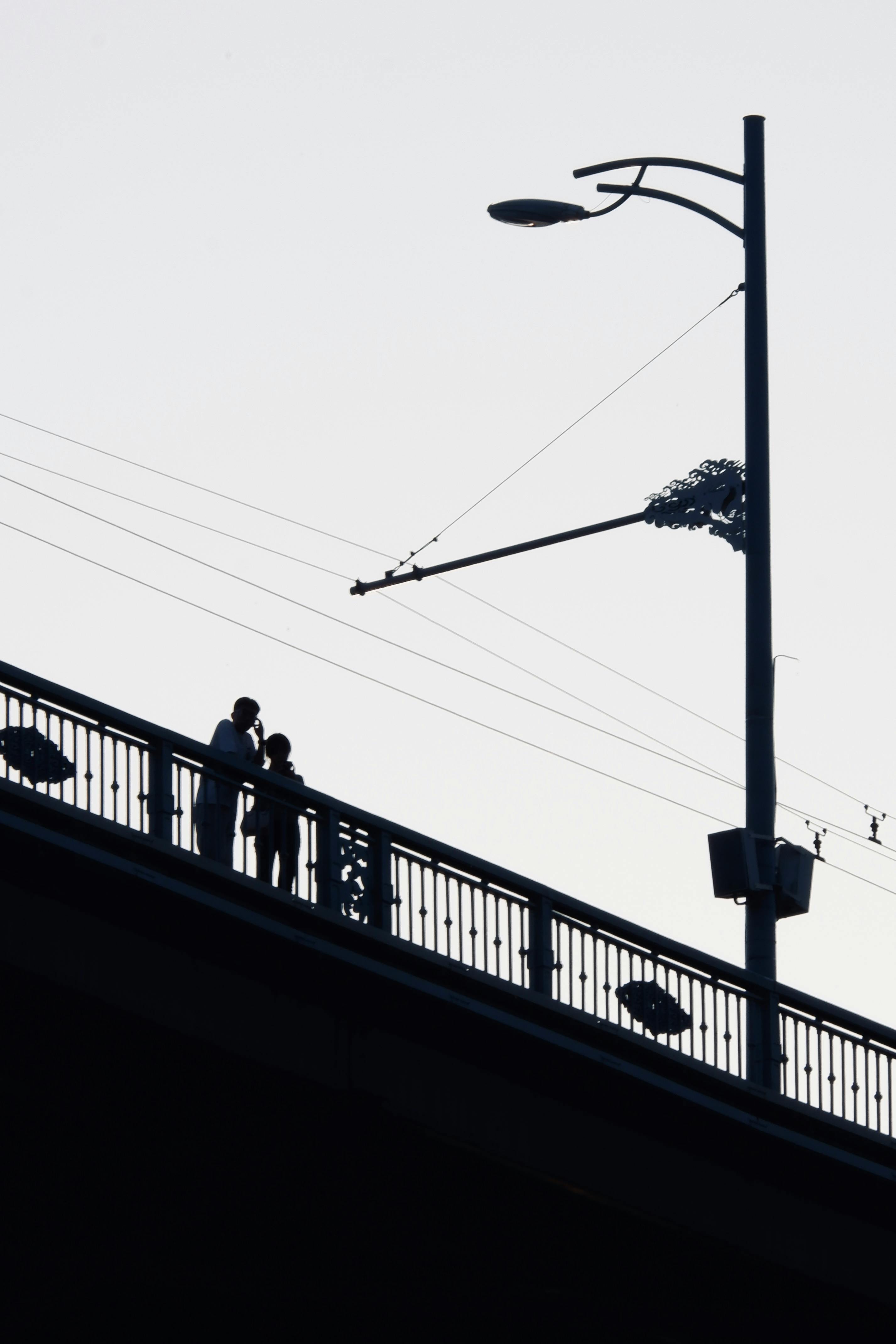 Silhouetted Figures on Urban Bridge at Dusk · Free Stock Photo Silhouetted Figures on Urban Bridge at Dusk · Free Stock Photo
