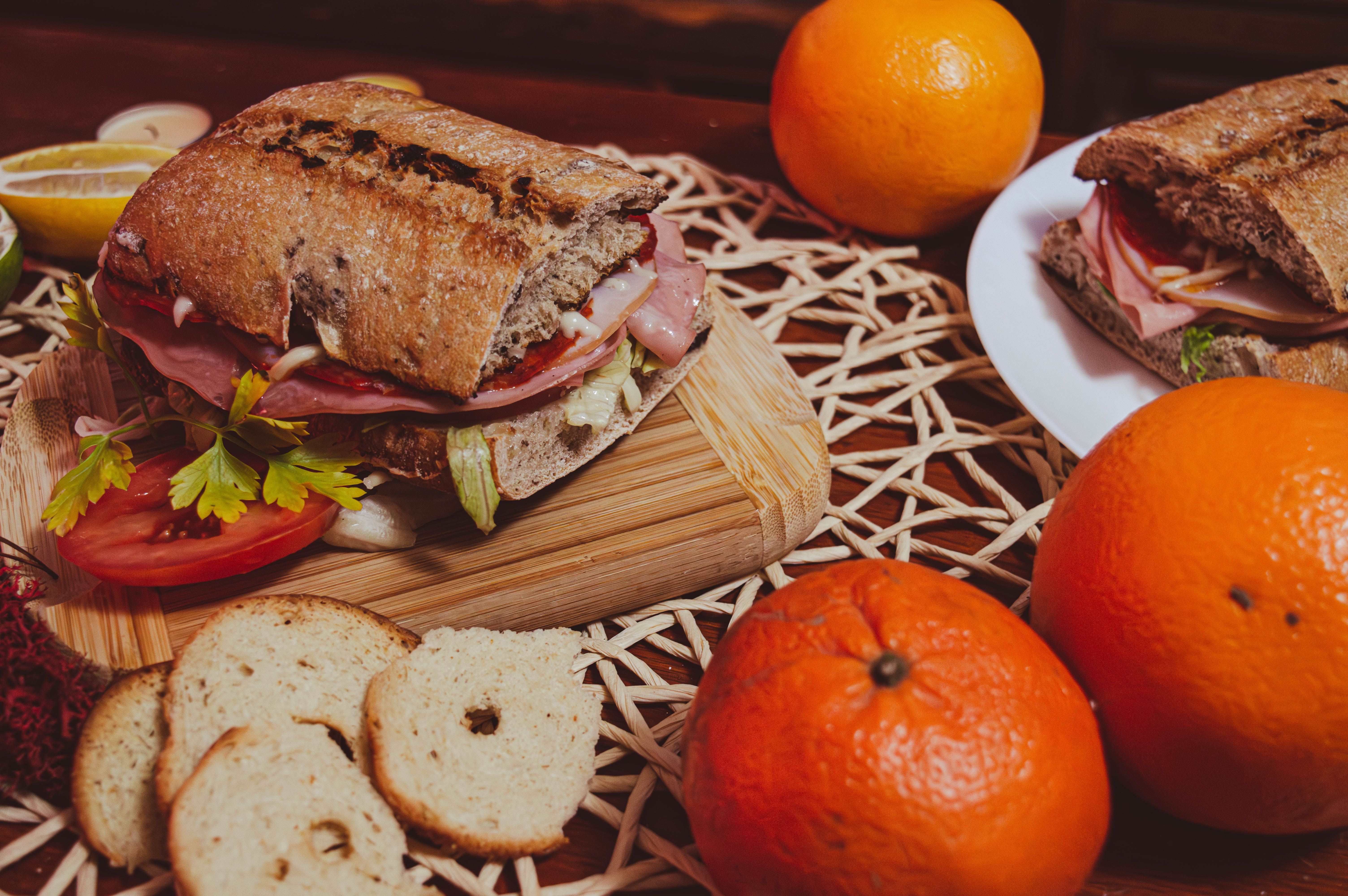 Gourmet Sandwich with Fresh Oranges on Rustic Table · Free Stock Photo