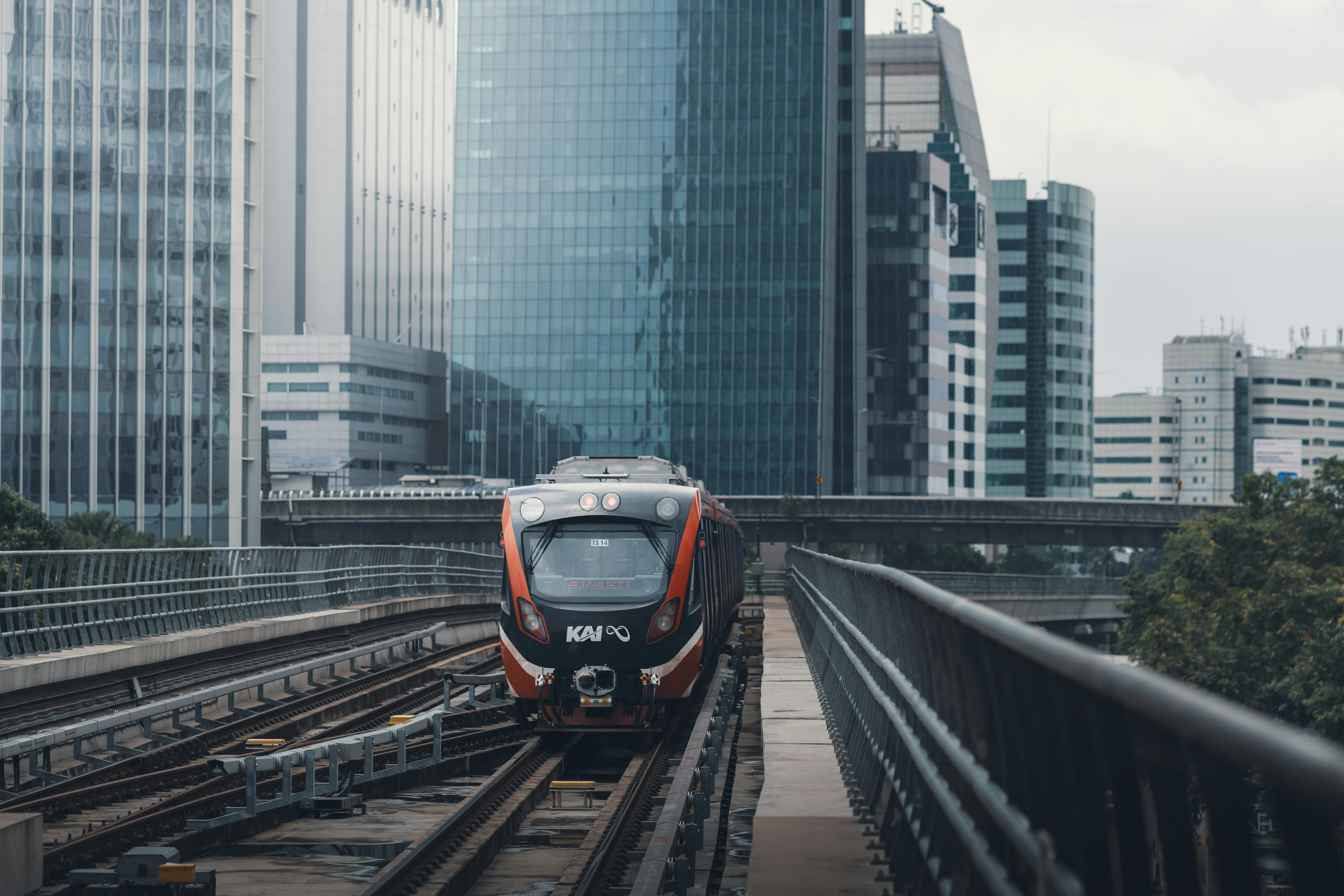 Modern Urban Train Passing Through Cityscape · Free Stock Photo