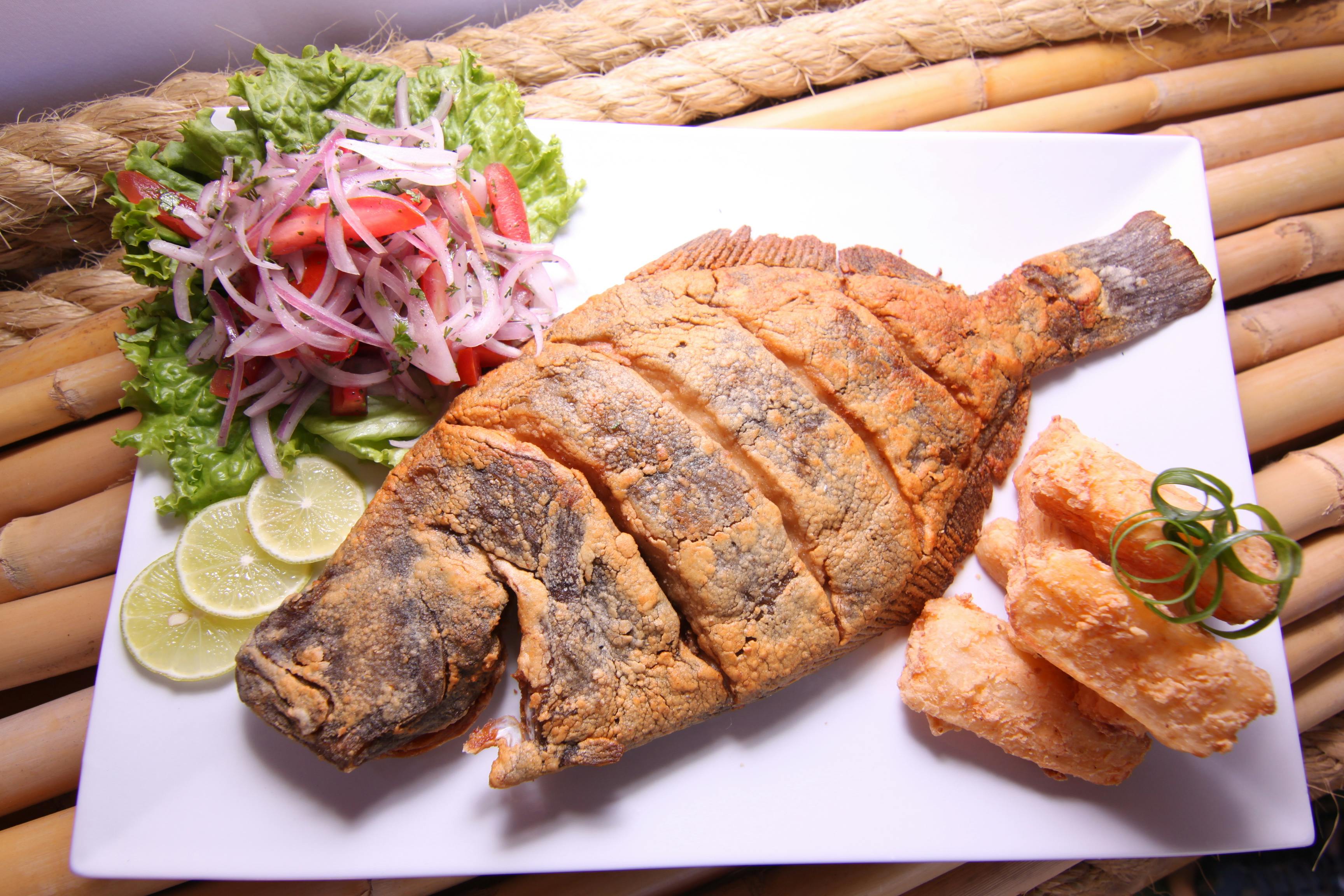 Pescado Frito Peruano Con Ensalada Fresca Y Yuca · Foto de stock gratuita
