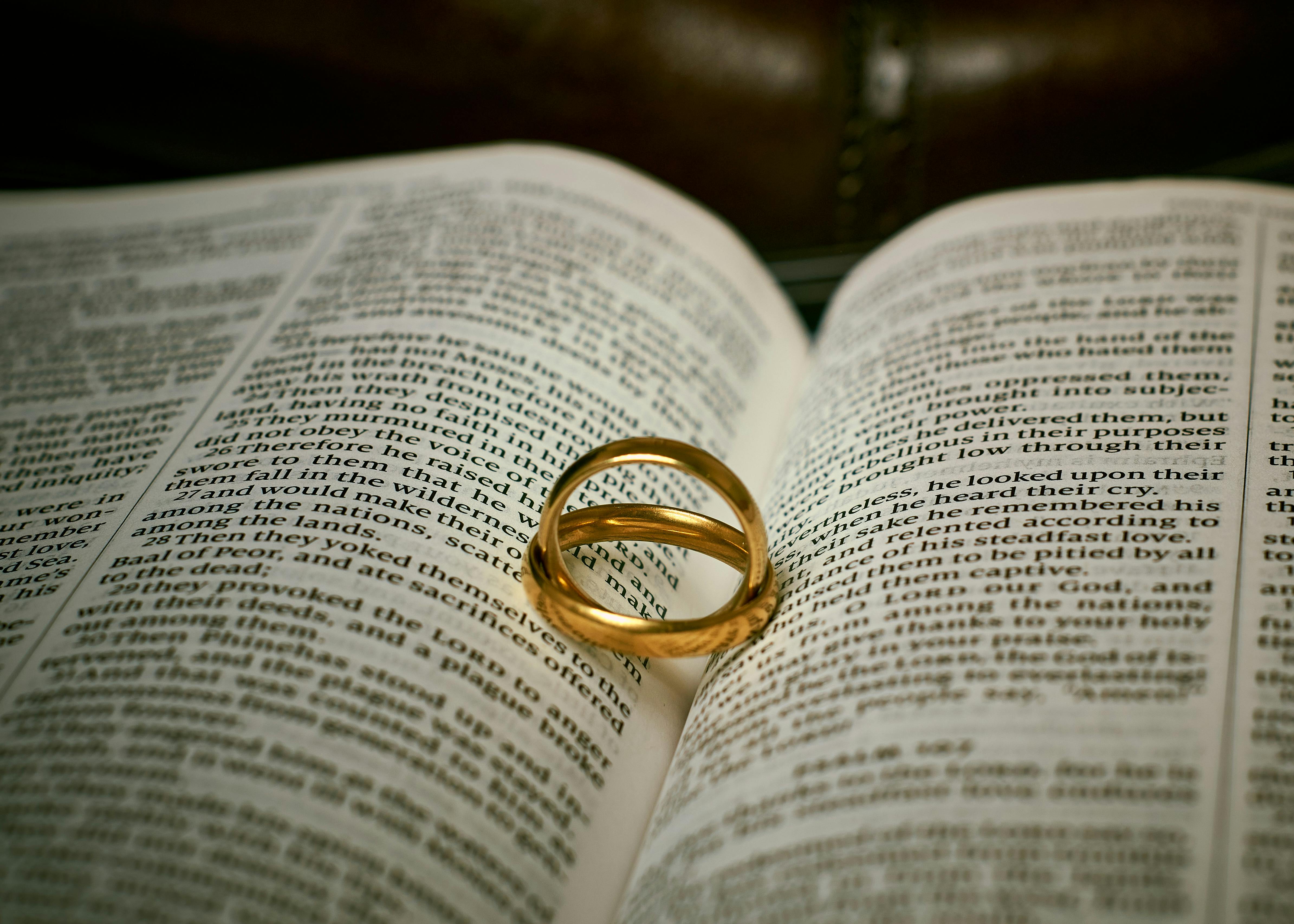 Golden Wedding Rings on Open Bible Page · Free Stock Photo