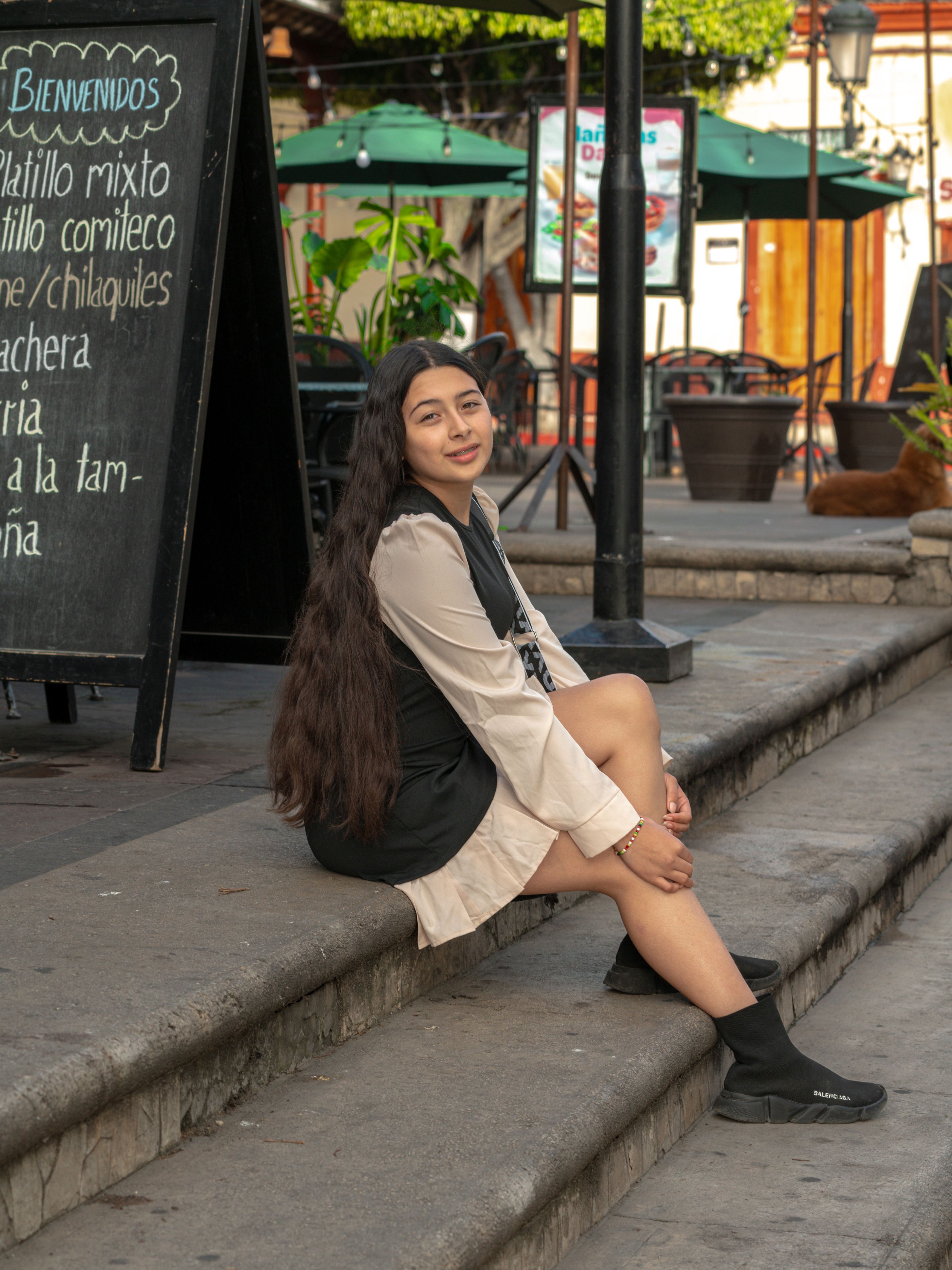Young woman sitting on city street steps outdoors · Free Stock Photo
