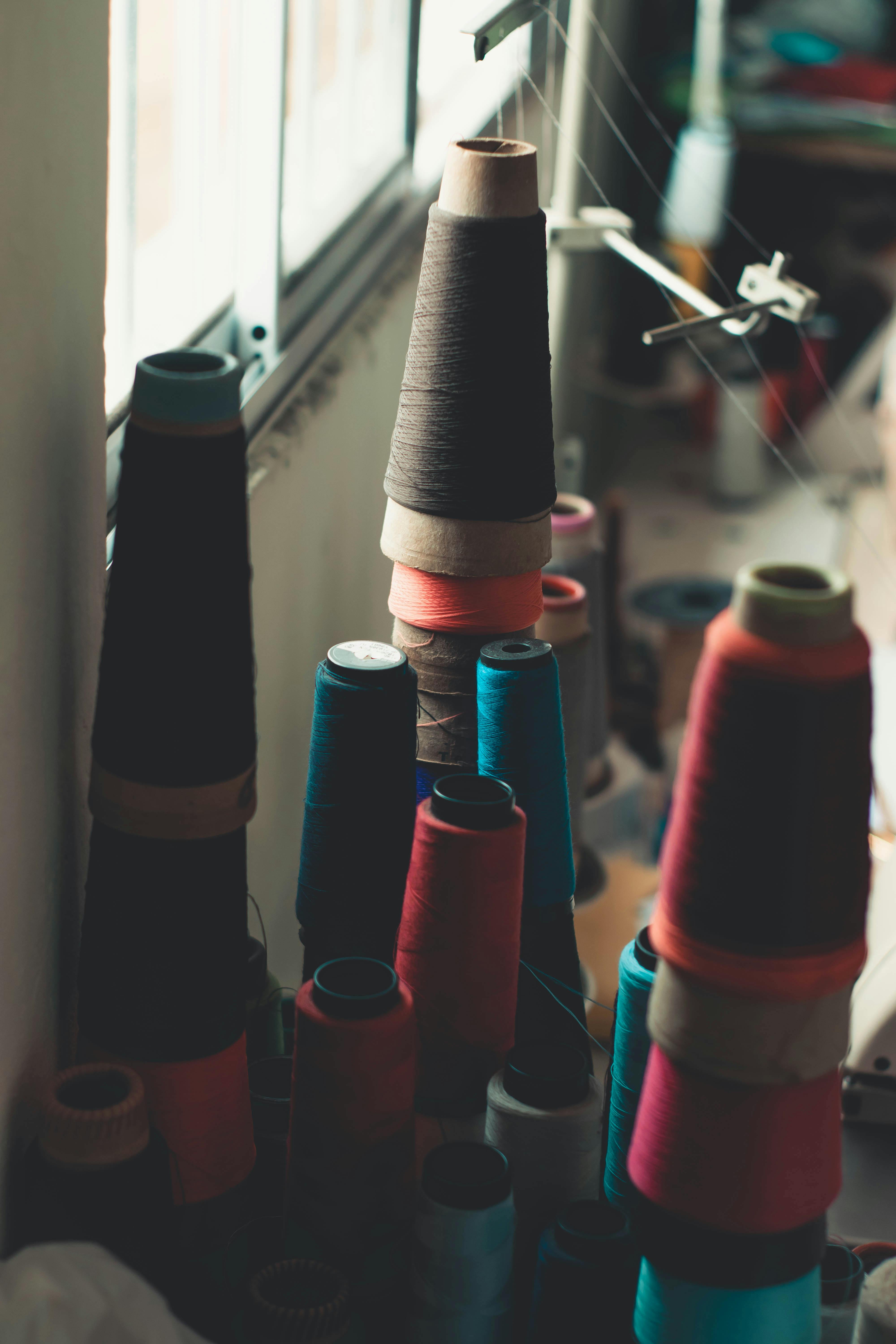 Pile of Thread Rolls Beside Window · Free Stock Photo