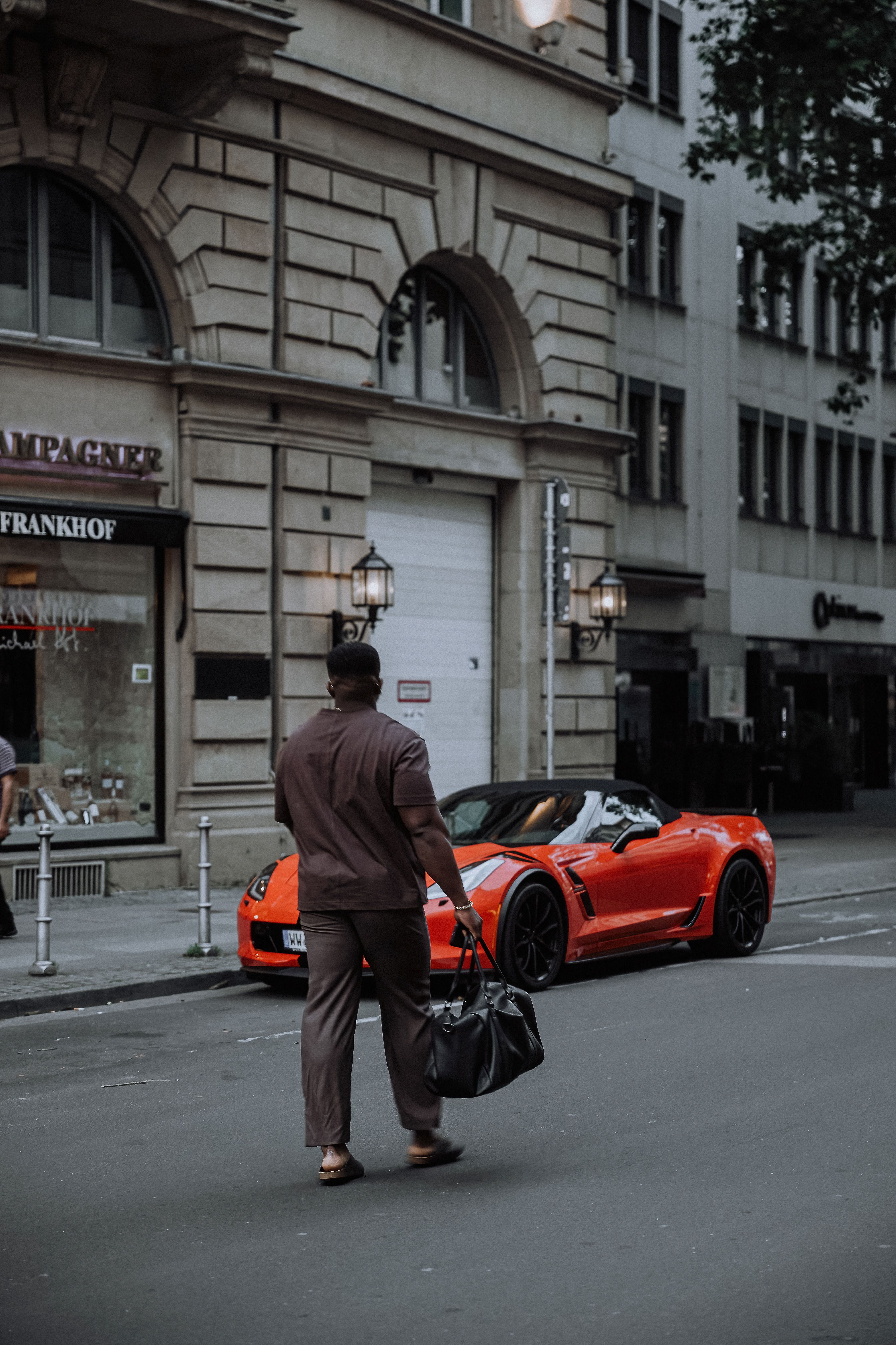 Man Approaching Red Sports Car on City Street · Free Stock Photo