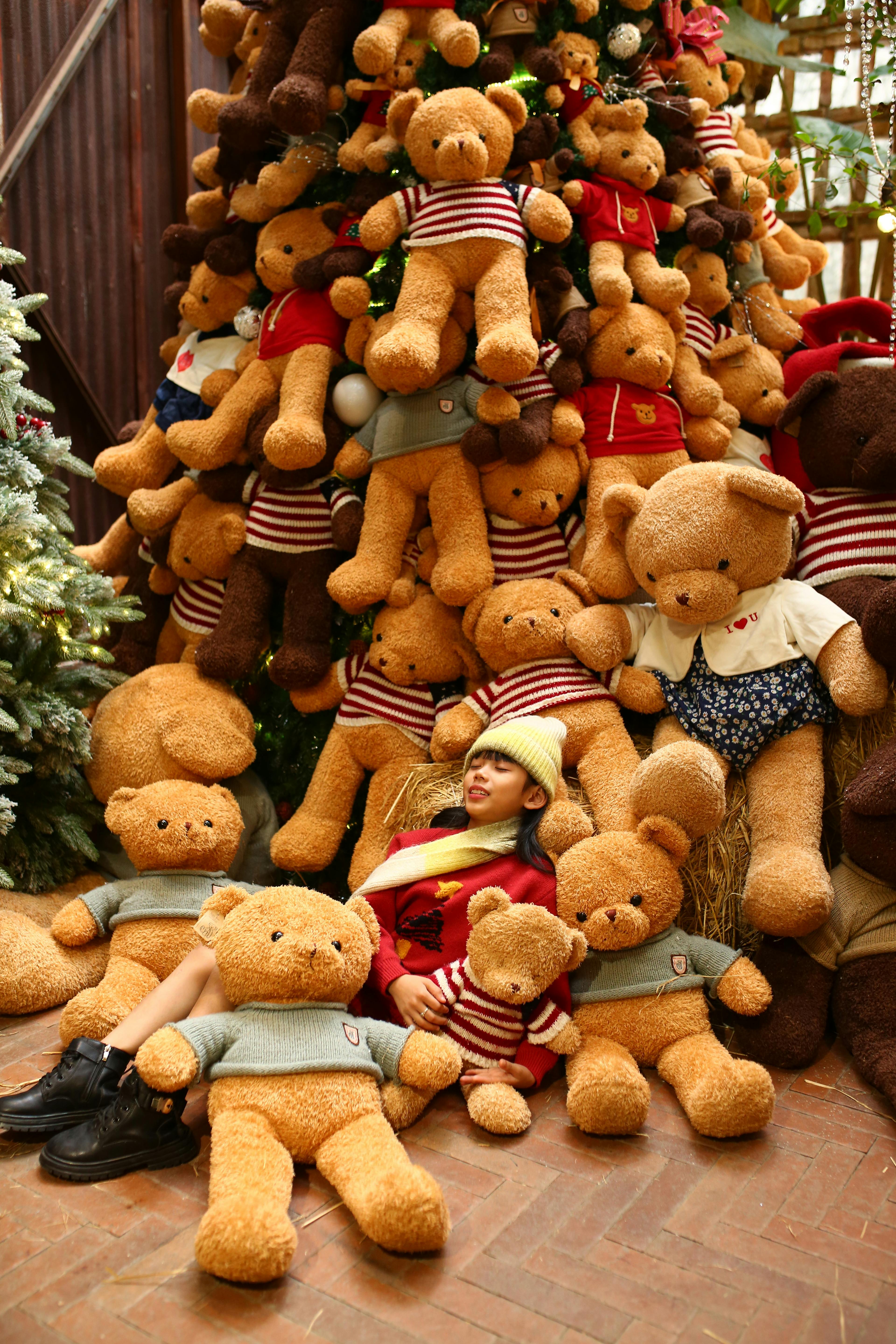 Young Woman Amidst Teddy Bear Tower in Hoi An · Free Stock Photo
