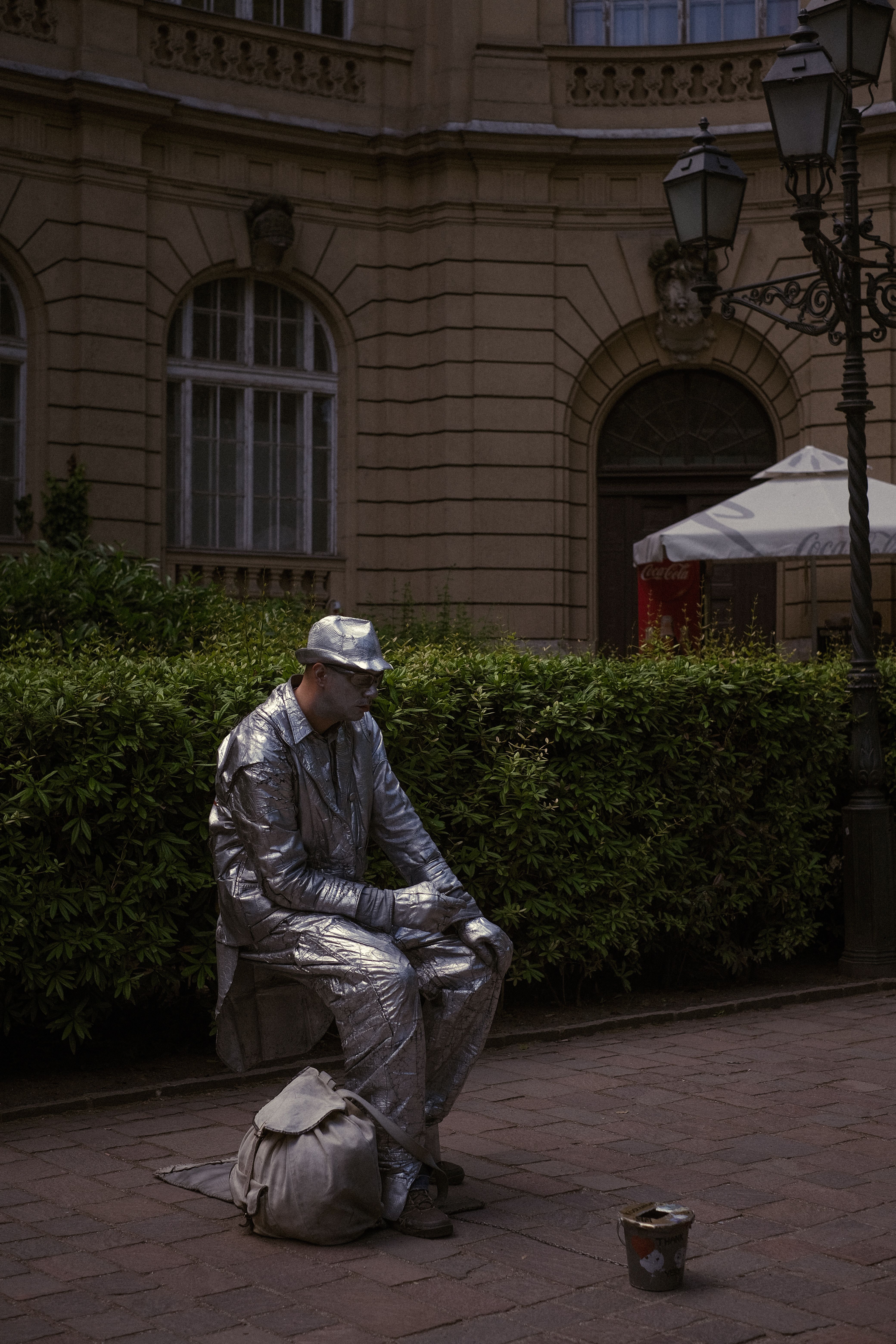Street Performer in Metallic Costume Sitting Outdoors · Free Stock Photo