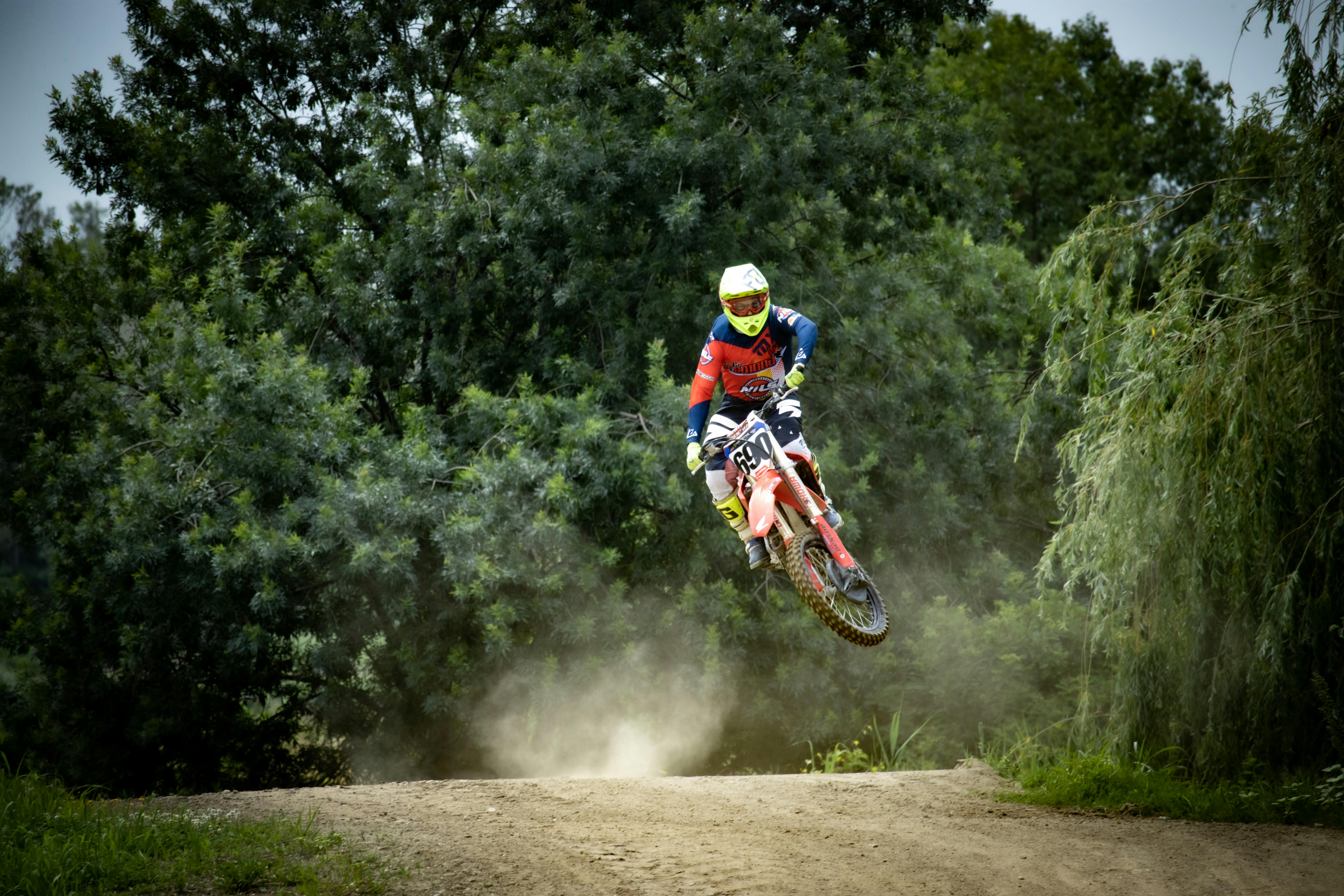Dynamic Motocross Jump in Forest Setting · Free Stock Photo