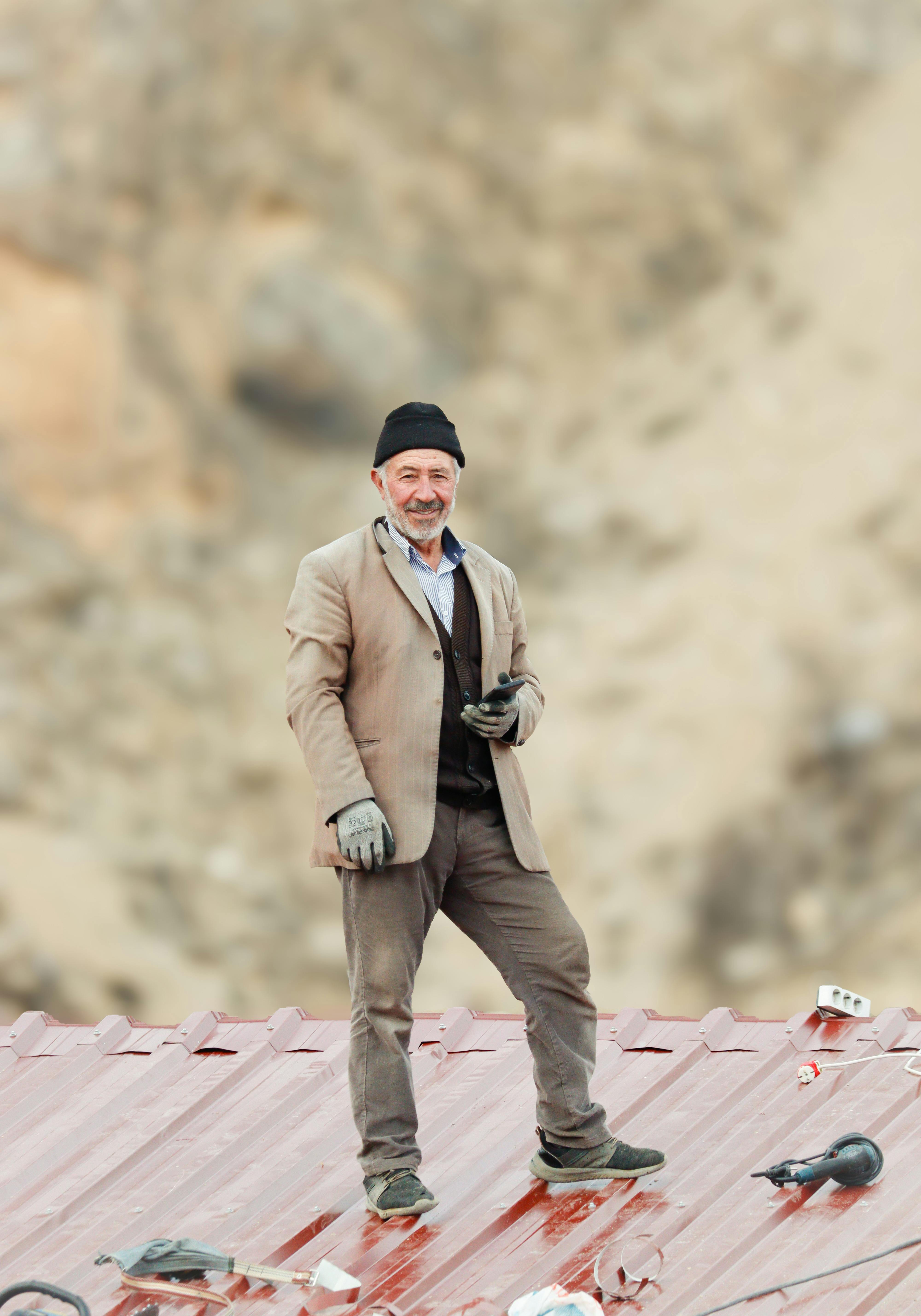 Man Standing on Rooftop with Mountain Background · Free Stock Photo