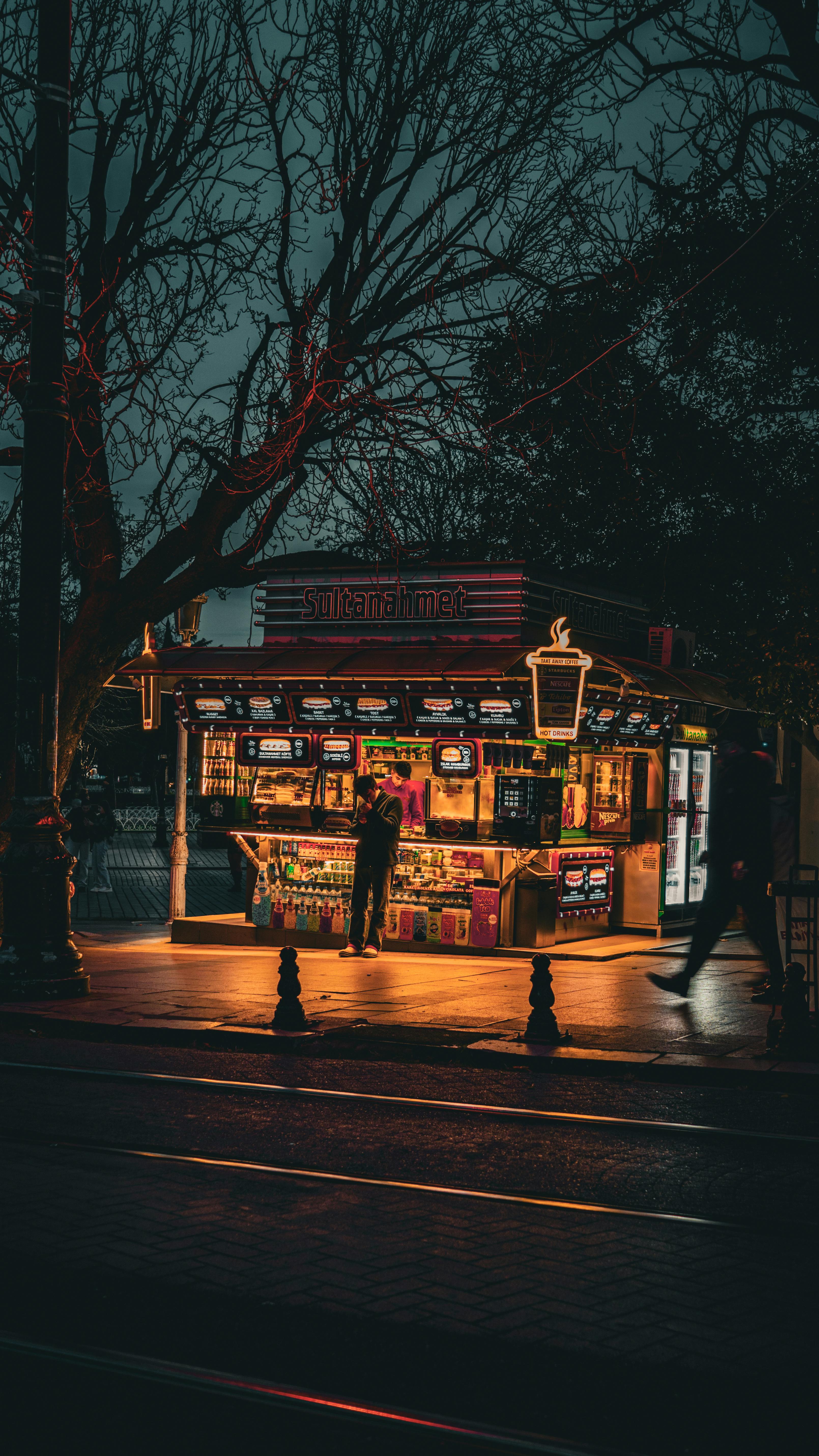 Illuminated Street Food Stall at Night in Urban Setting · Free Stock Photo