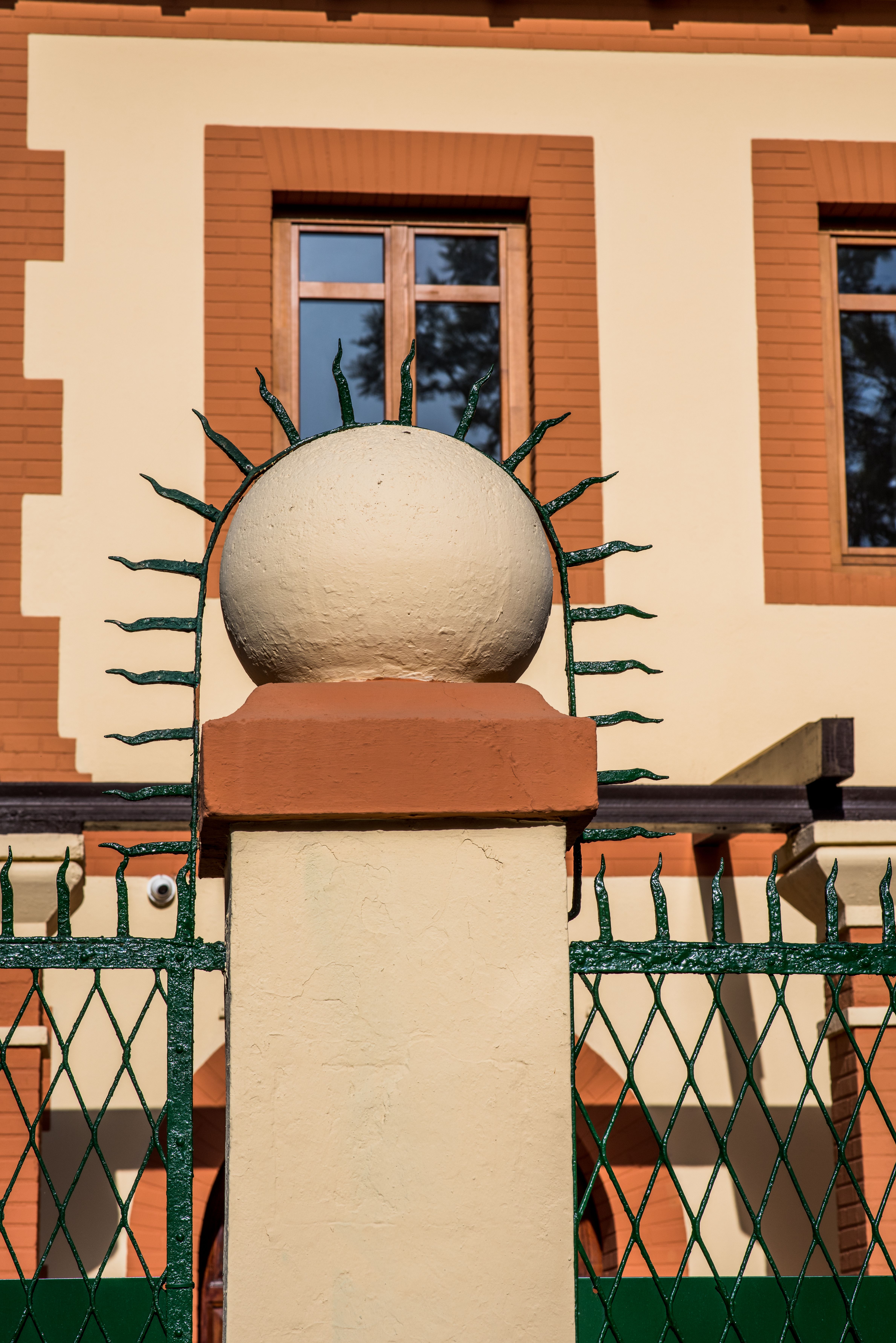 Ornate Fence Post with Sun Motif in Urban Setting · Free Stock Photo
