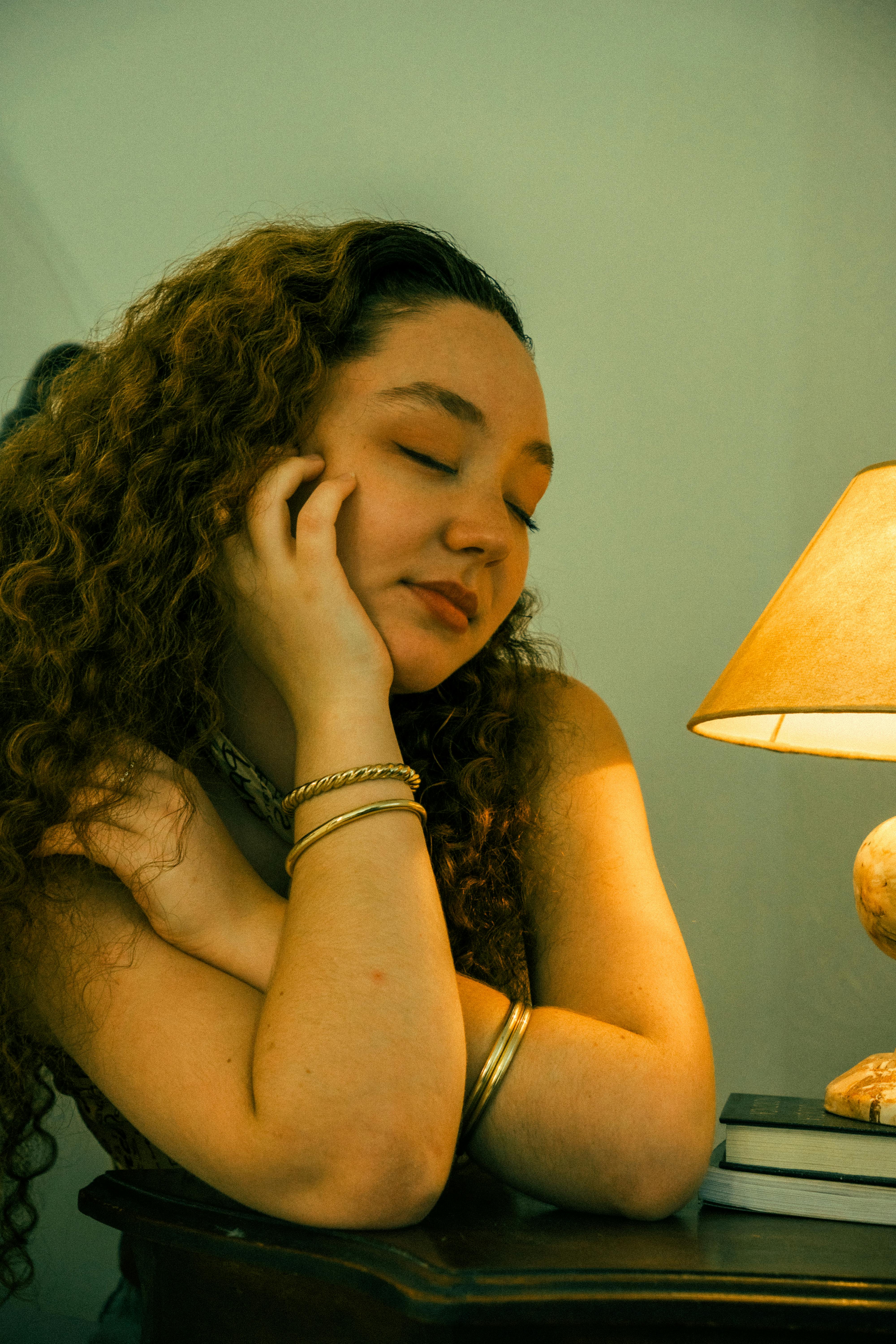 Relaxed Woman by Lamp Contemplating in Warm Light · Free Stock Photo