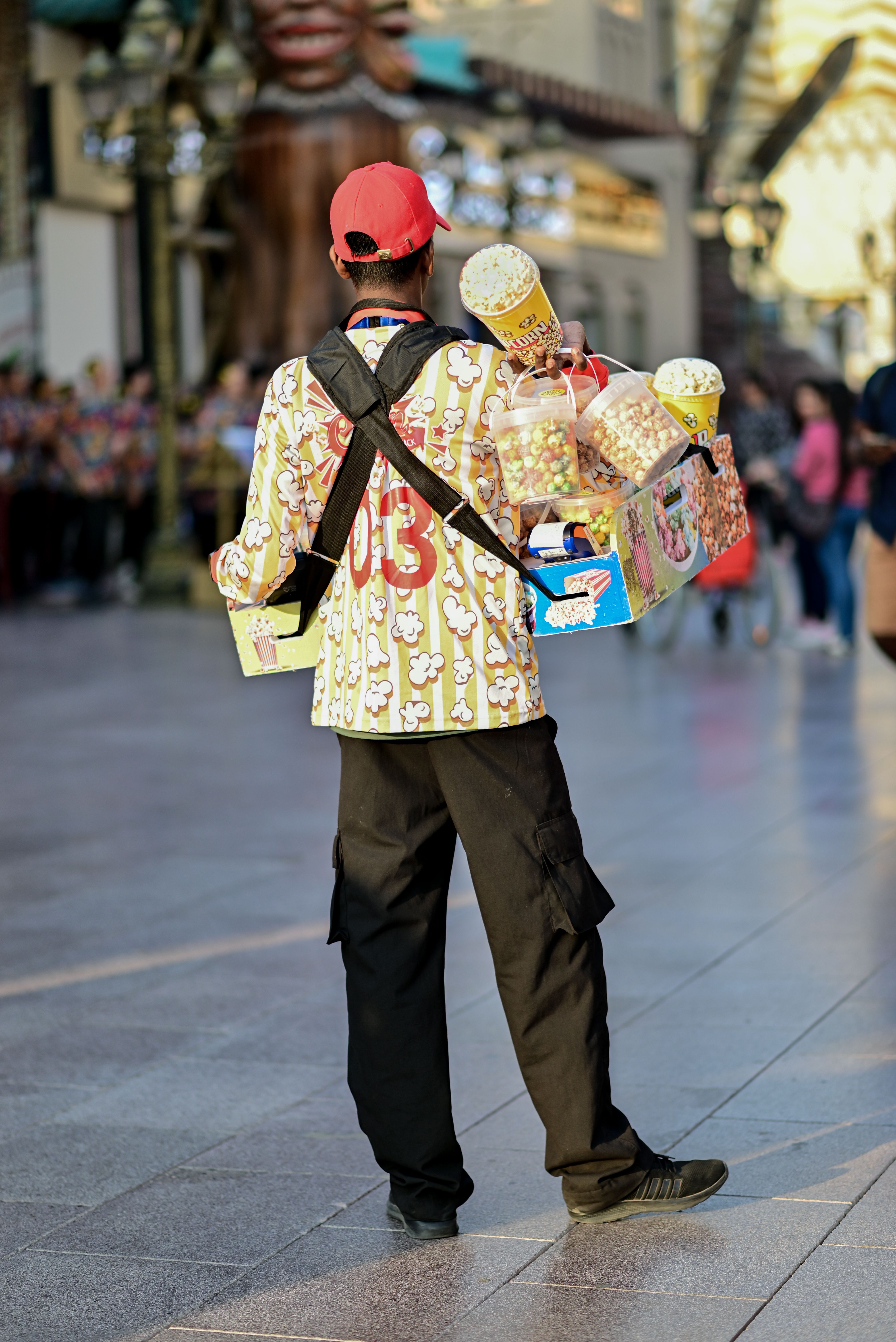 Street Vendor Selling Colorful Snacks in Busy Area · Free Stock Photo