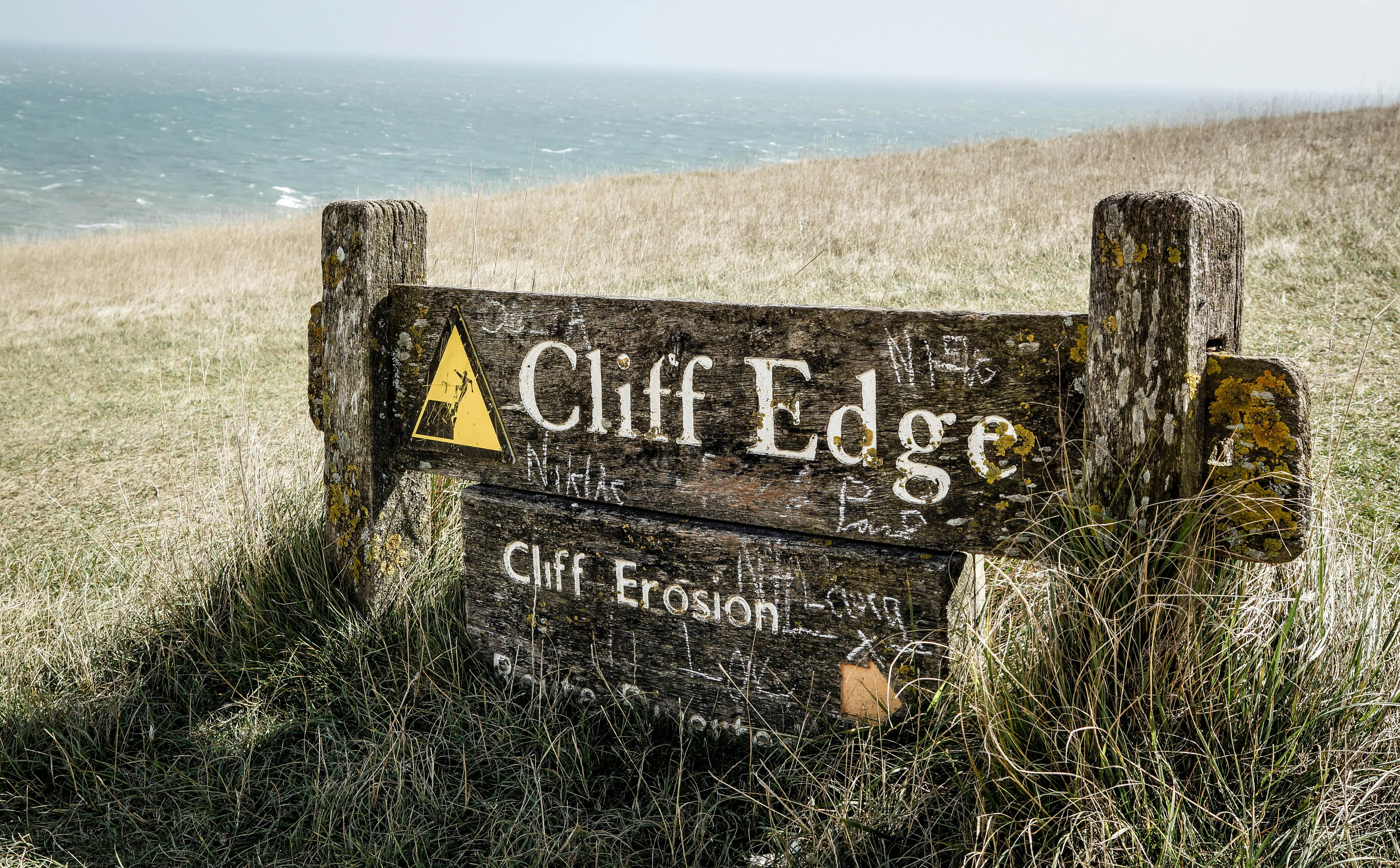 Warning Sign for Cliff Edge Erosion with Ocean View · Free Stock Photo