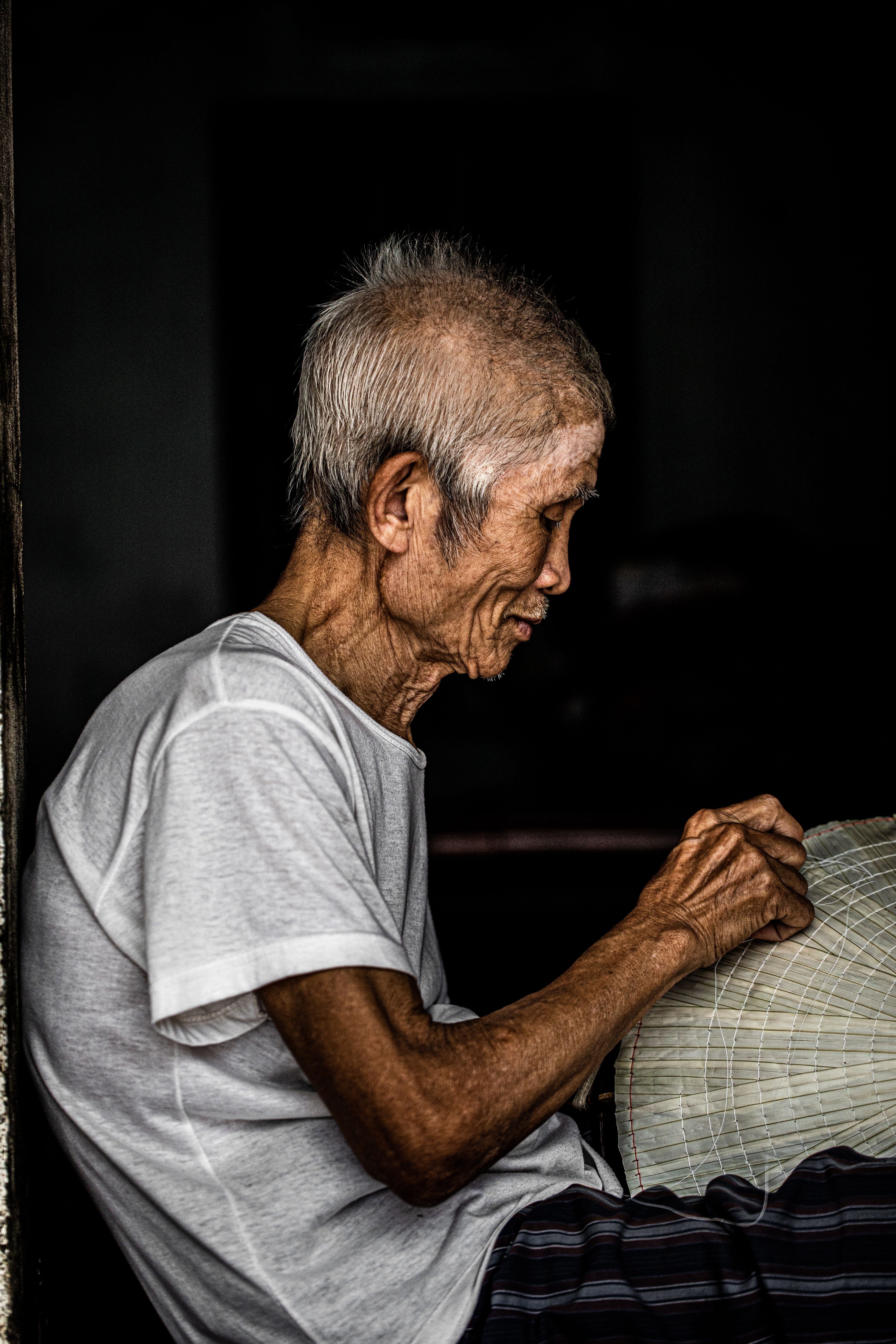 Elderly Man Crafting Traditional Asian Object · Free Stock Photo