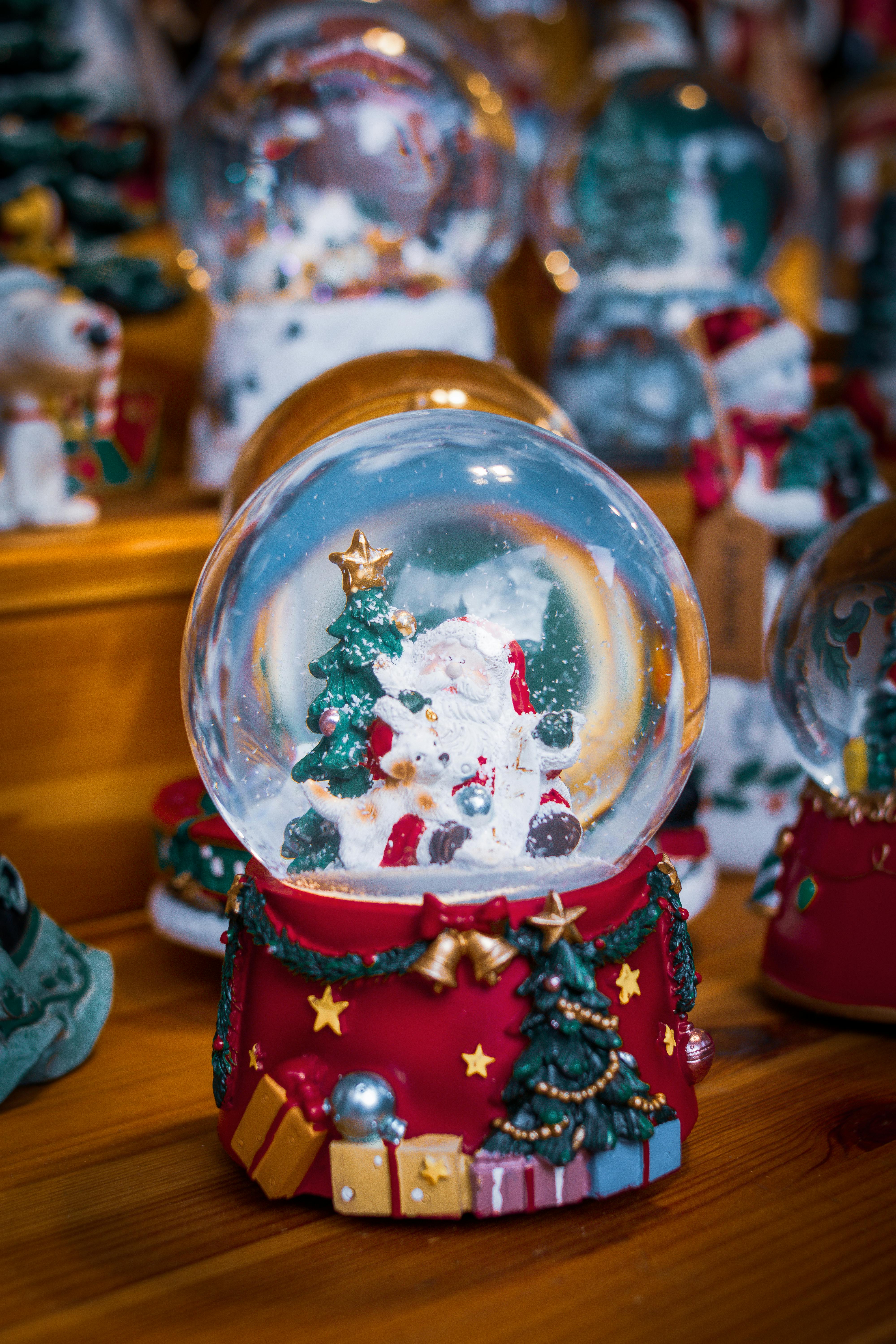 Festive Christmas Snow Globe Display at Market · Free Stock Photo