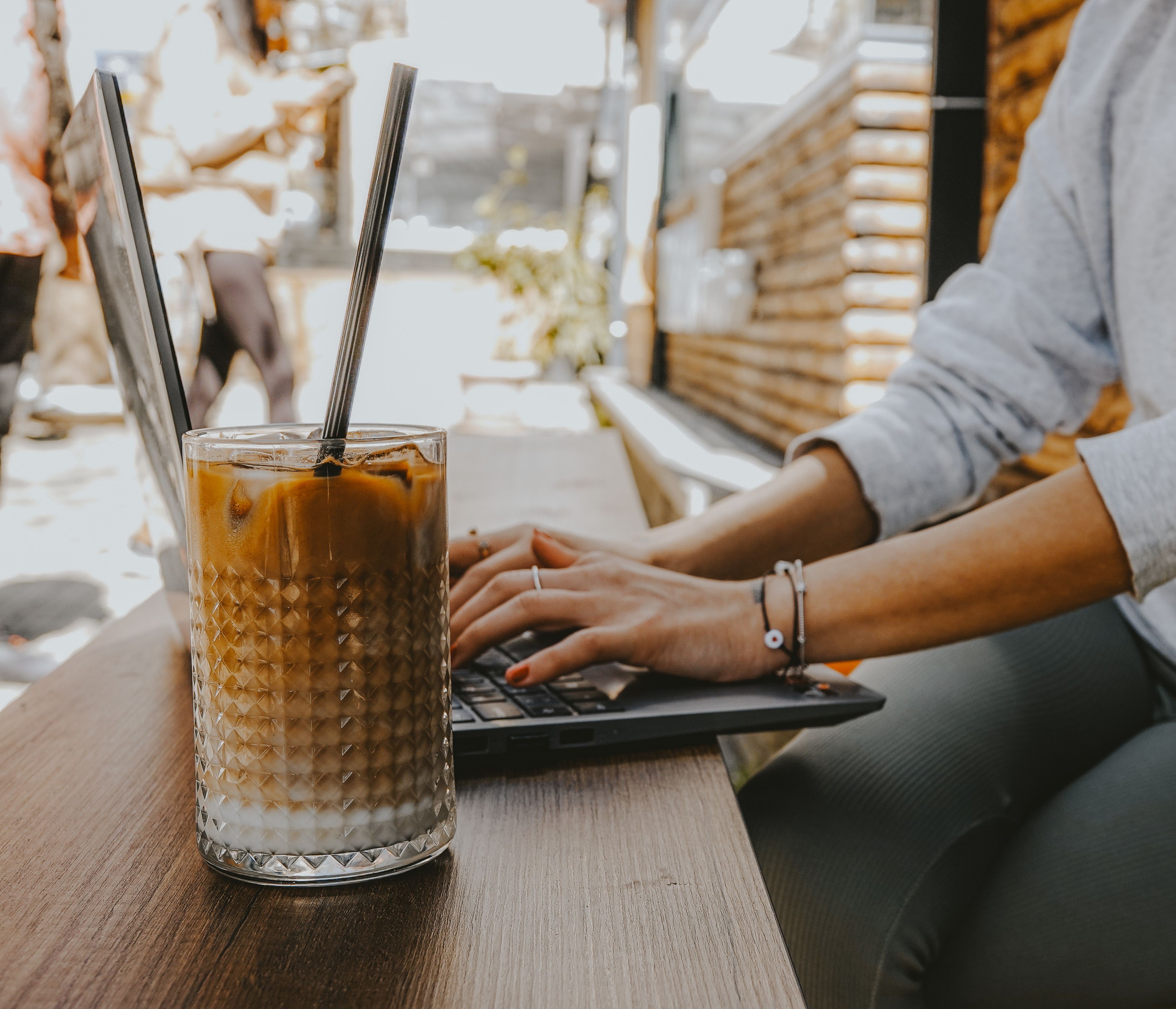 Warm Outdoor Cafe Scene with Iced Latte · Free Stock Photo
