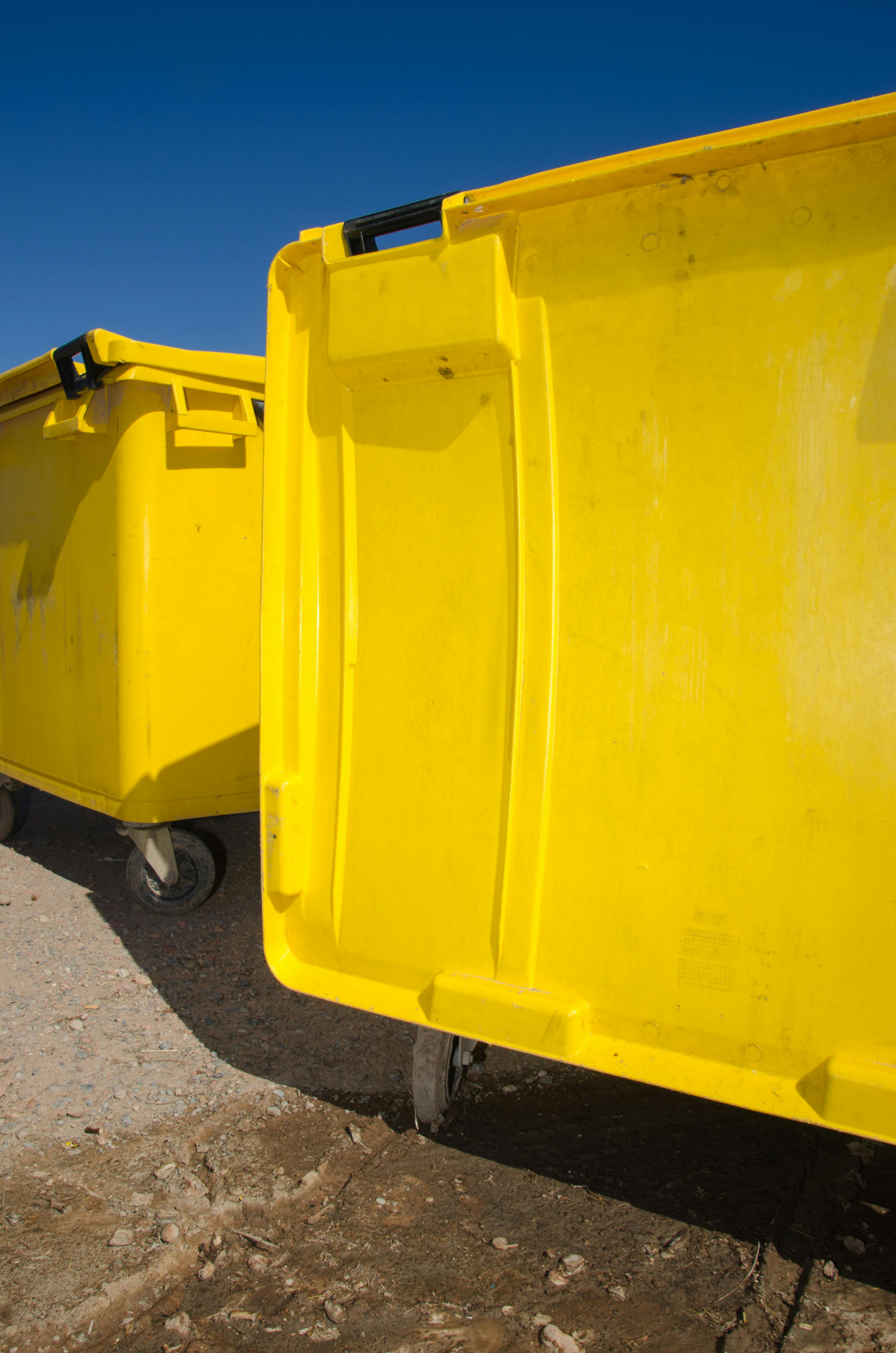 Vibrant Yellow Trash Bins in Outdoor Setting · Free Stock Photo