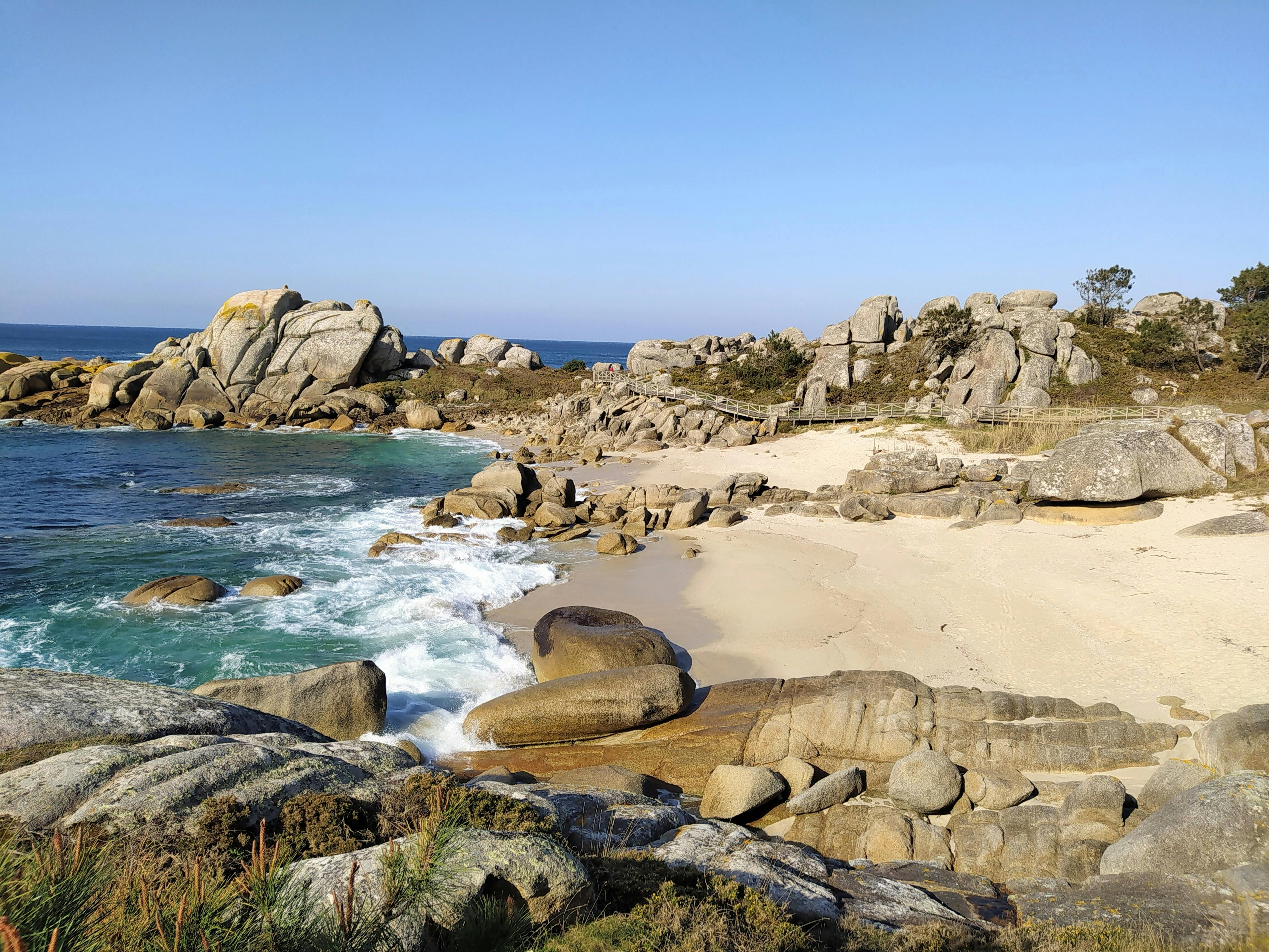 Scenic Rocky Coastal Beach with Clear Blue Waters · Free Stock Photo