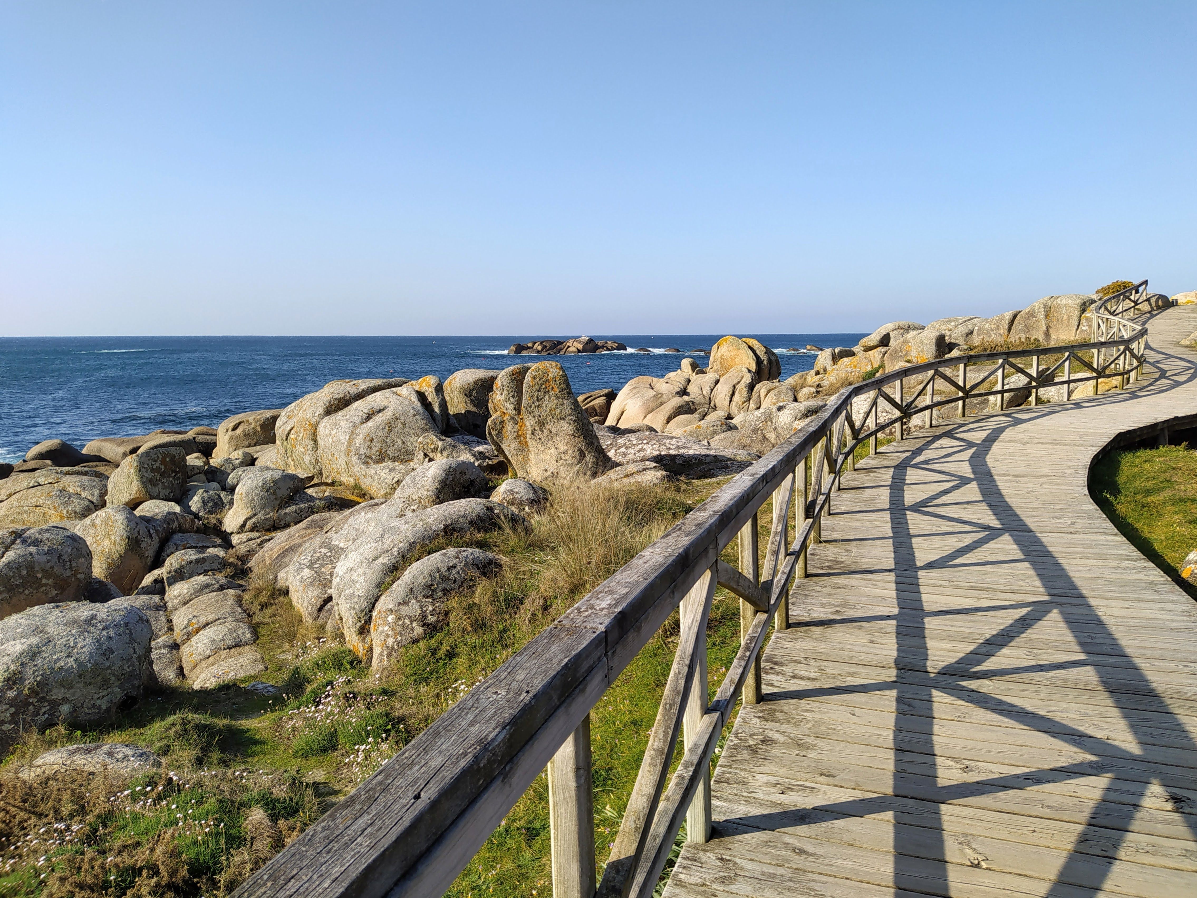 Scenic Coastal Boardwalk with Rocky Shoreline · Free Stock Photo