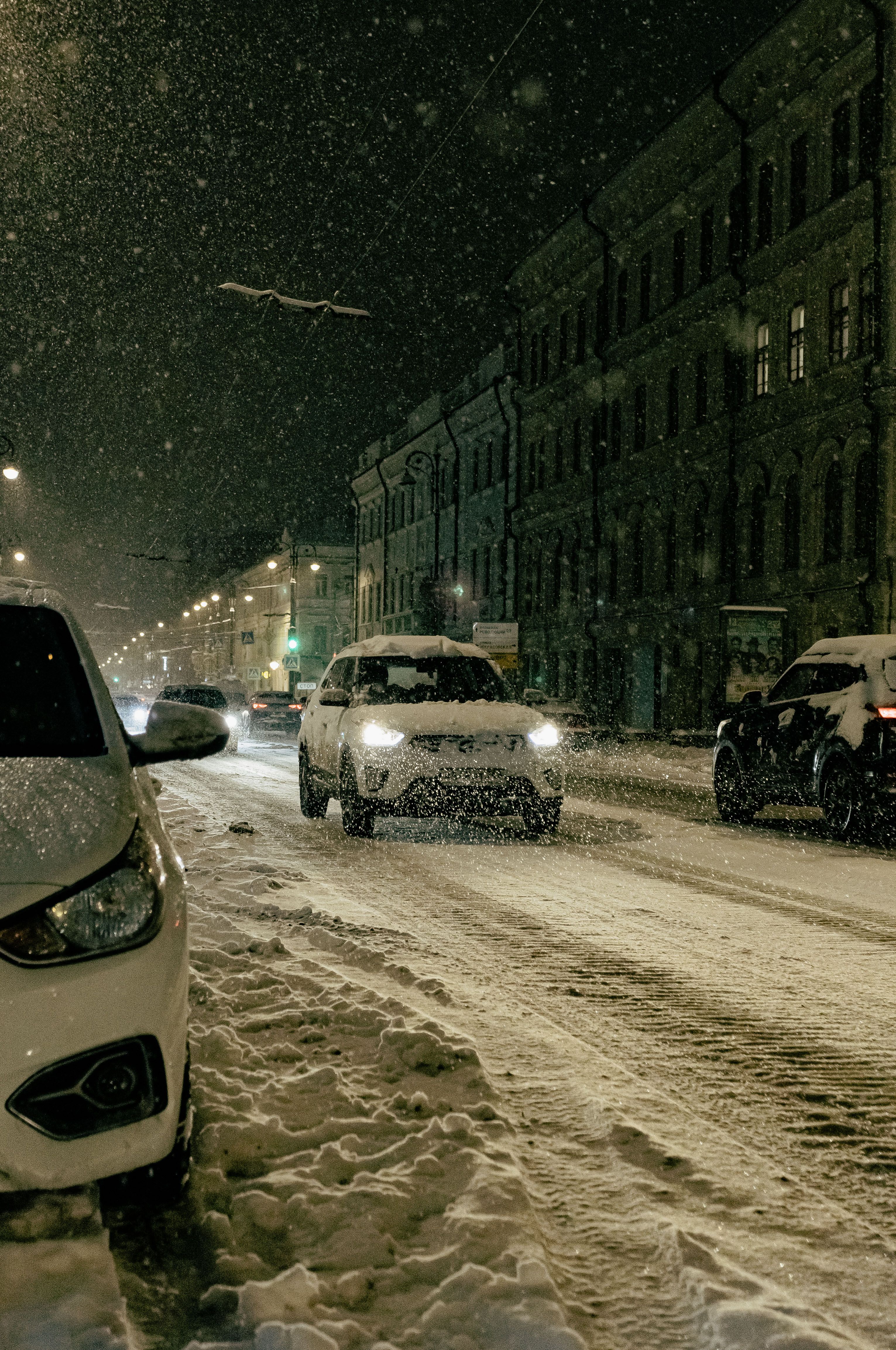 Snowy Night Urban Street with Cars Driving · Free Stock Photo