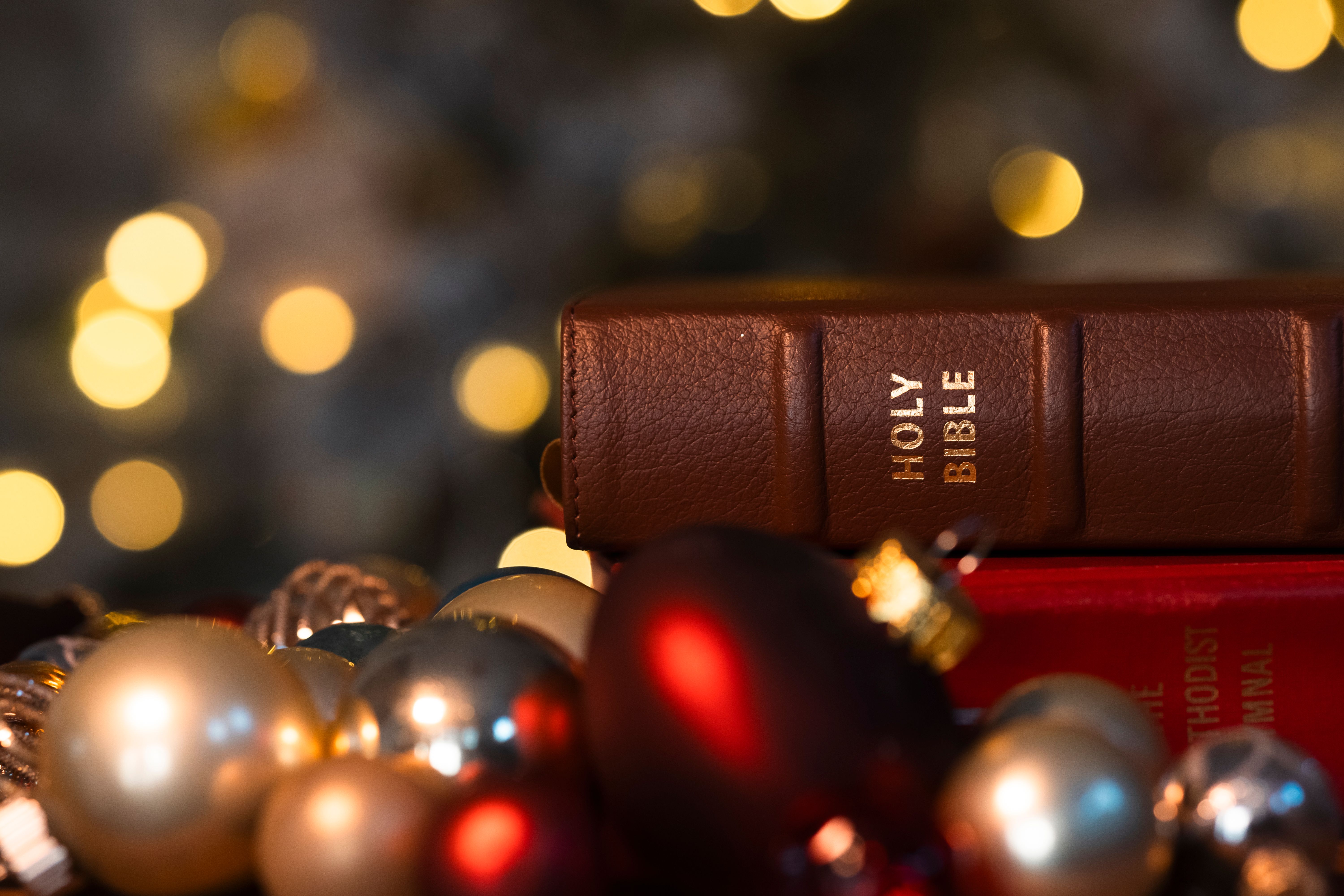 Festive Christmas Setting with Holy Bible and Ornaments · Free Stock Photo